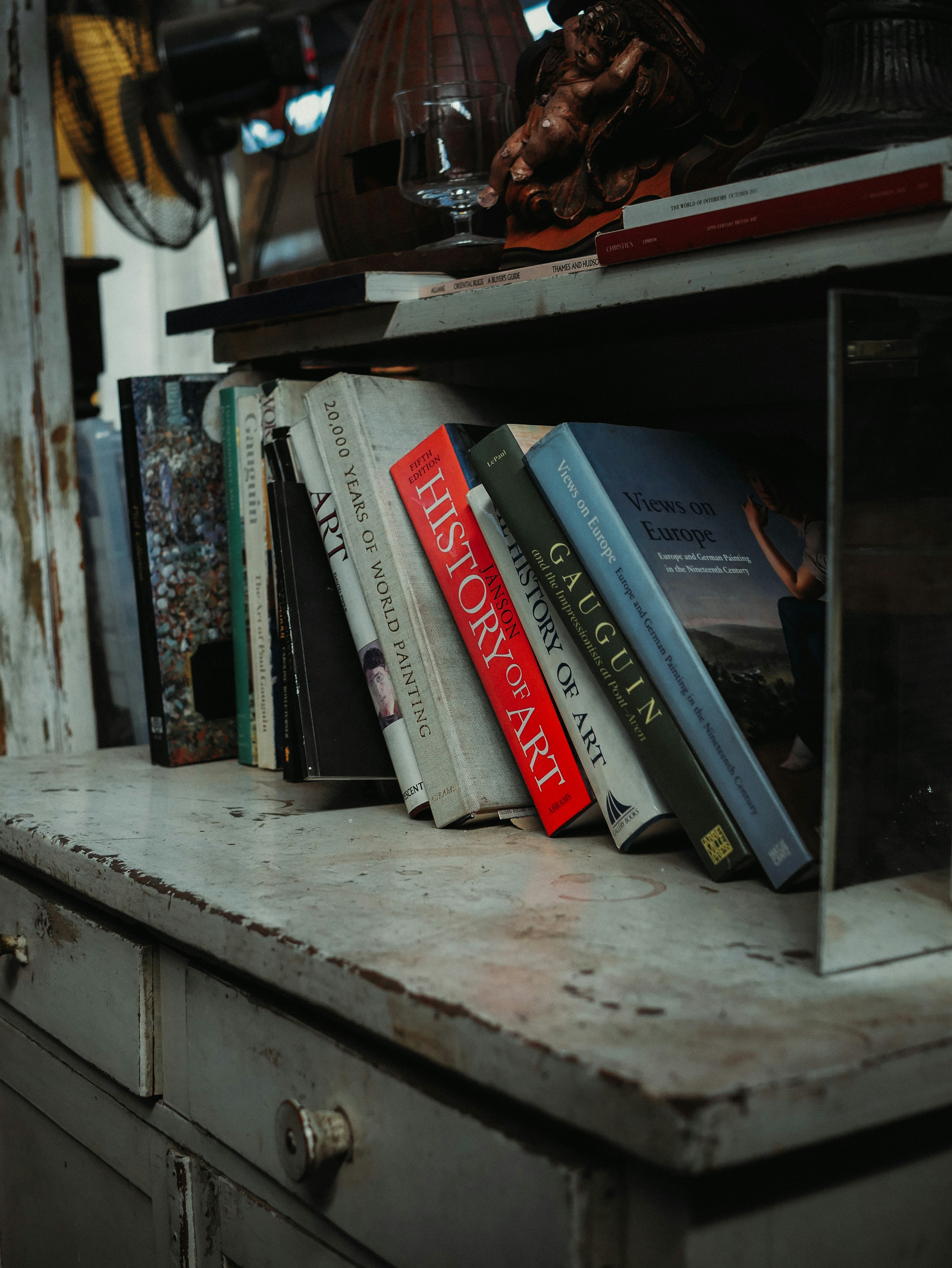 Red Spine of Art History Resting on a Weathered Bookshelf