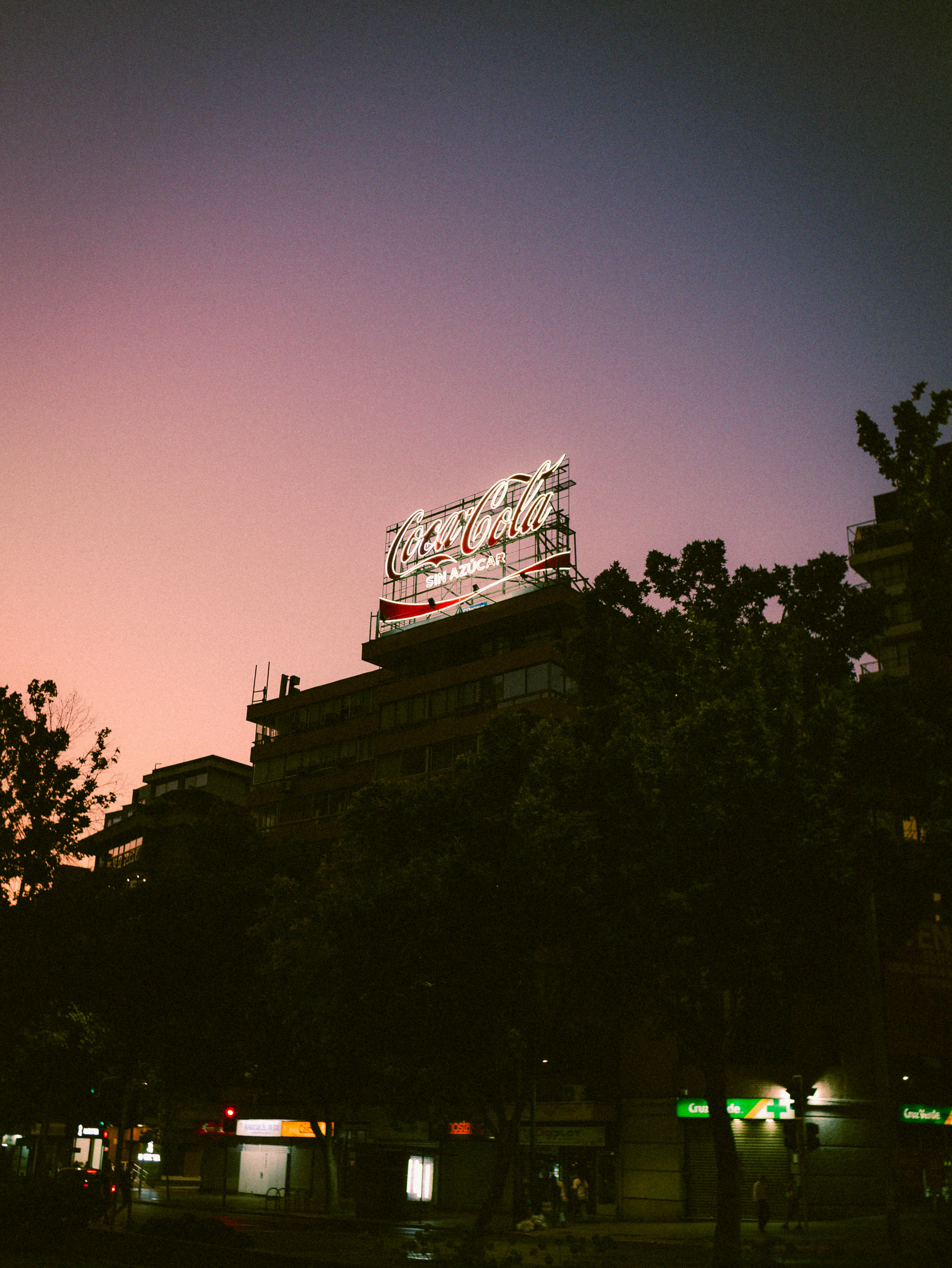 Coca-Cola Neon Crown Over a Dusk-Quiet City Block