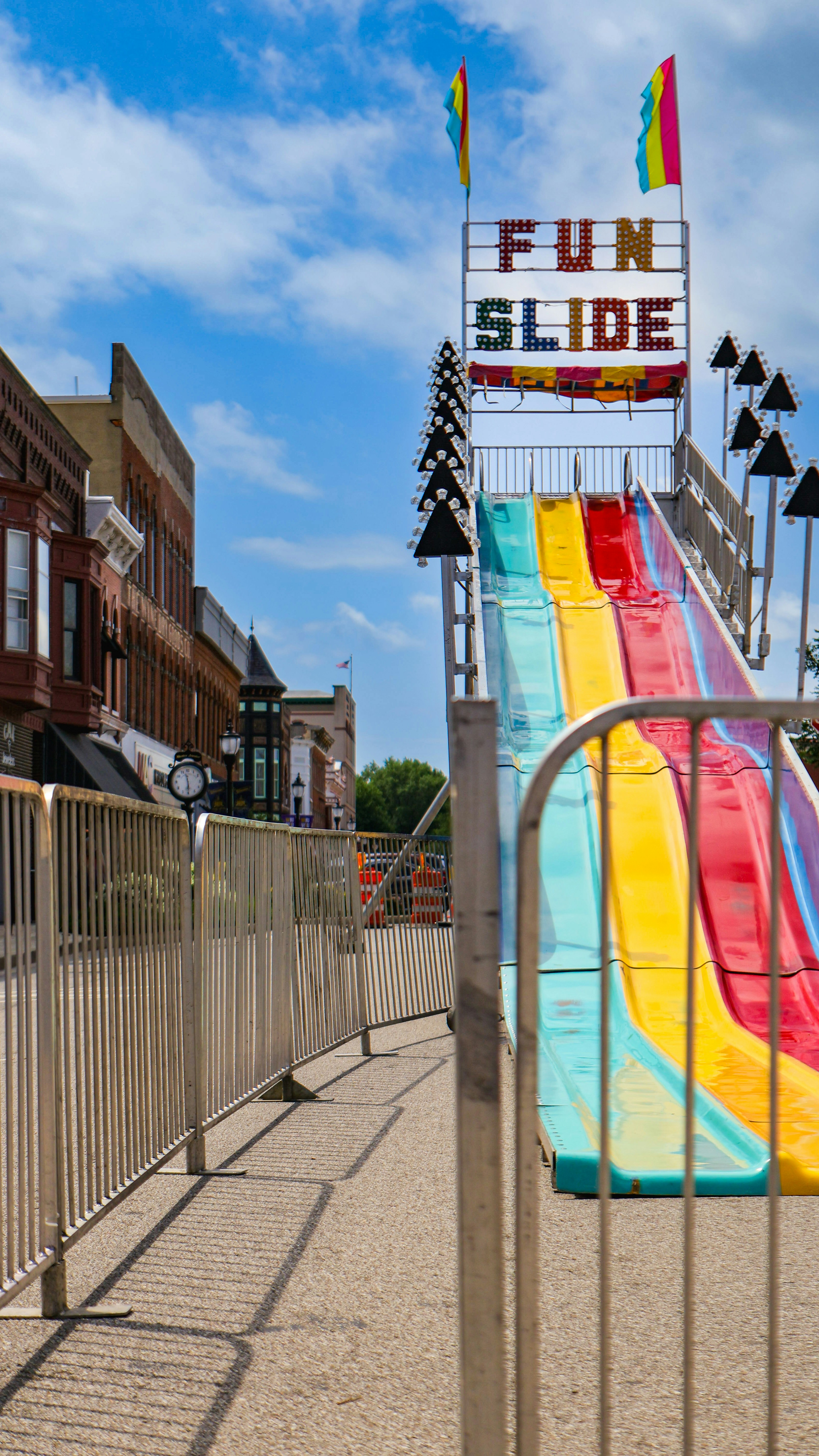Rainbow Slide Ascends Over a Sunlit Main Street Fair