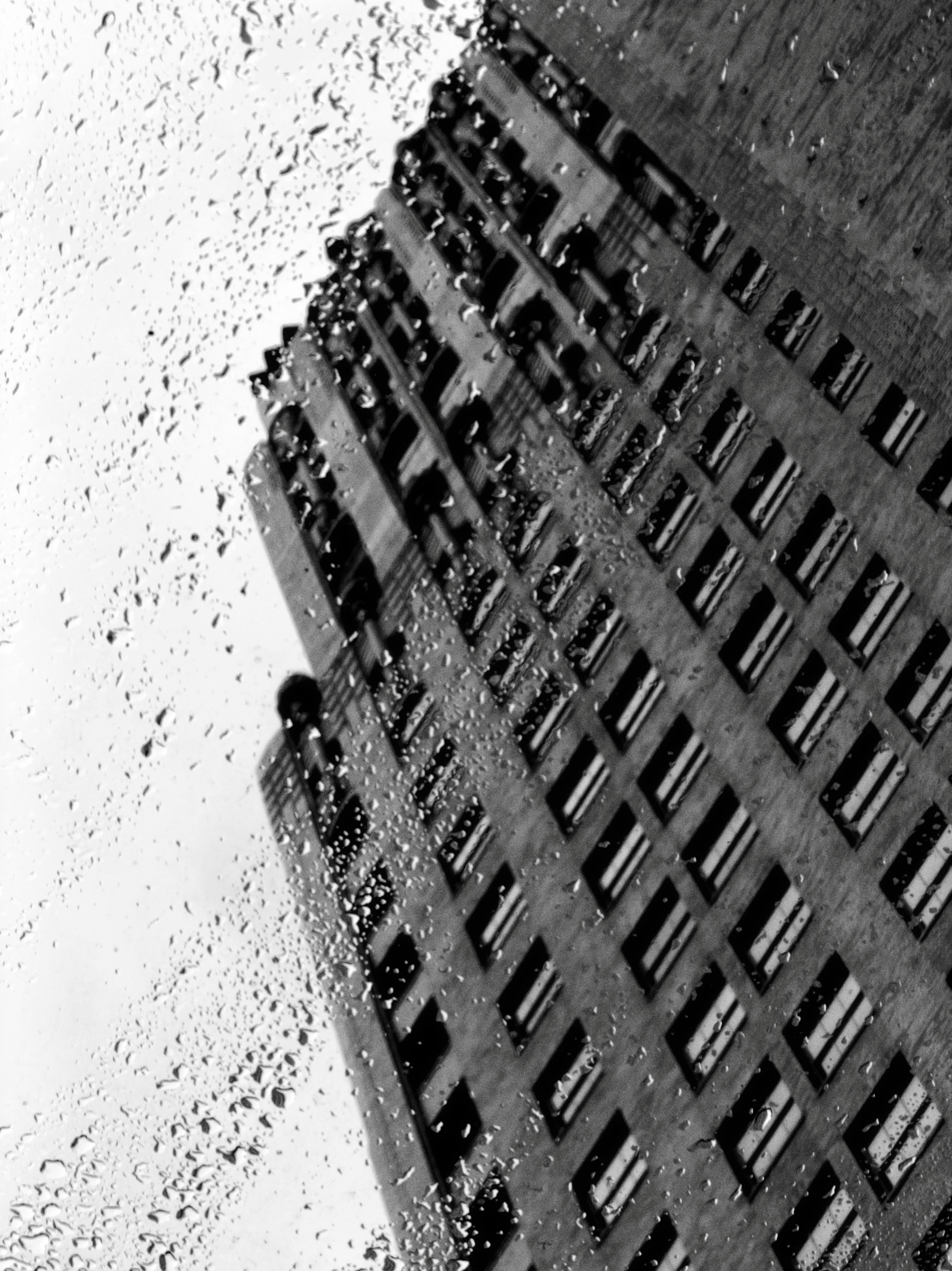 Monochrome Highrise: Rain-Splattered Angles on a Tilted Facade