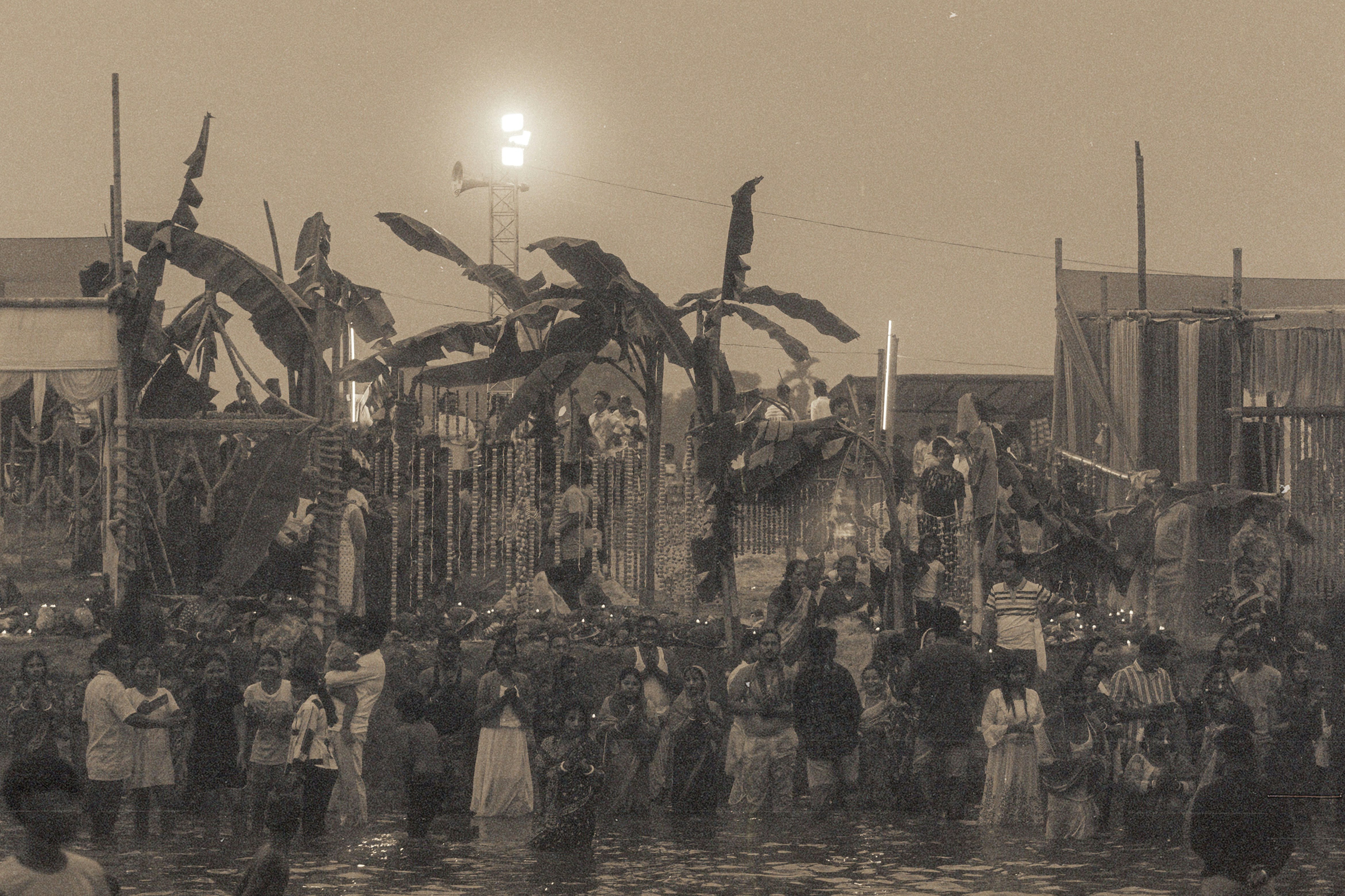 Lamp-lit Confluence: Crowds Wading Through a Flooded Settlement