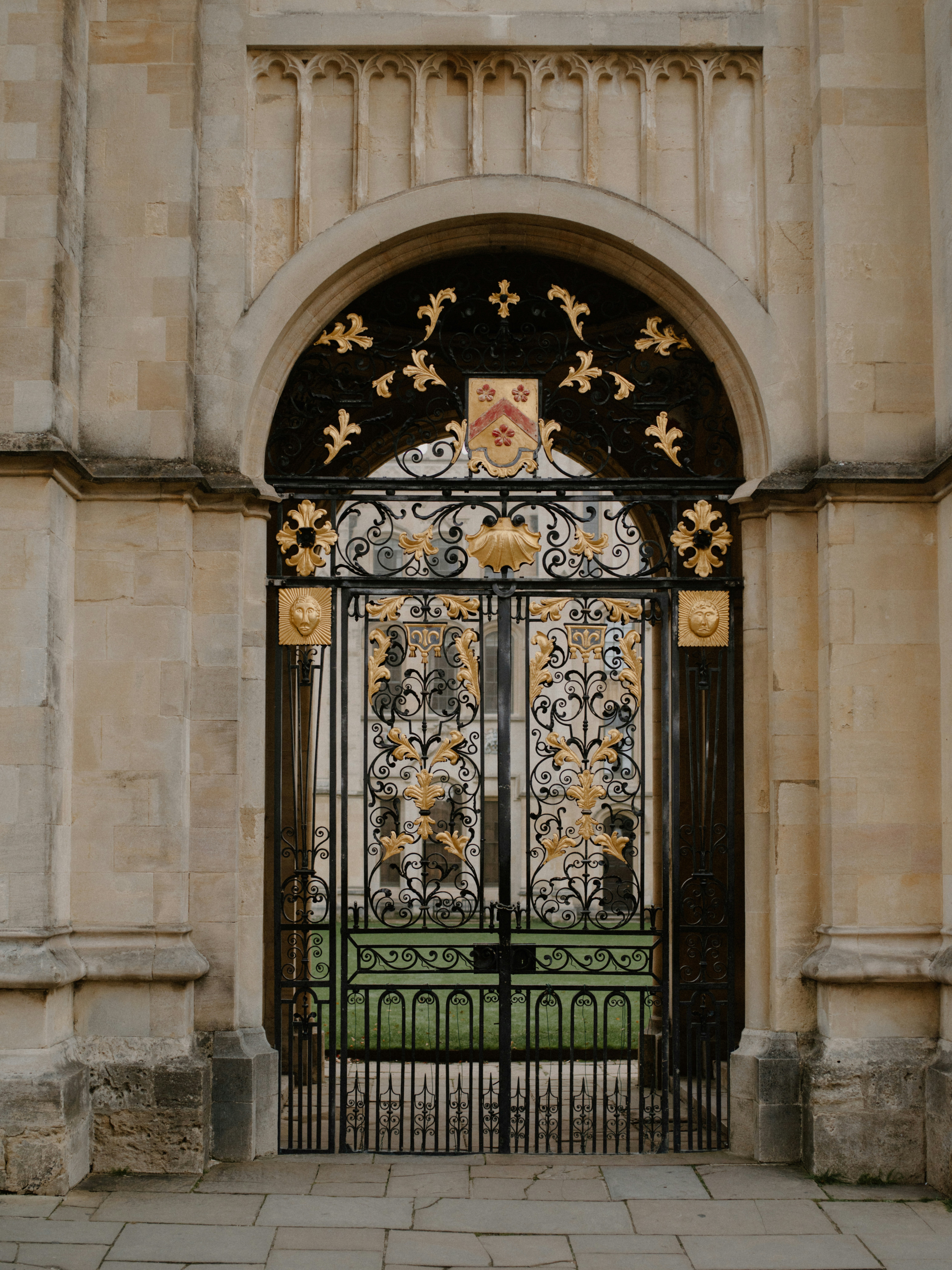 Gold-Embroidered Iron Gate Framed by a Limestone Arch