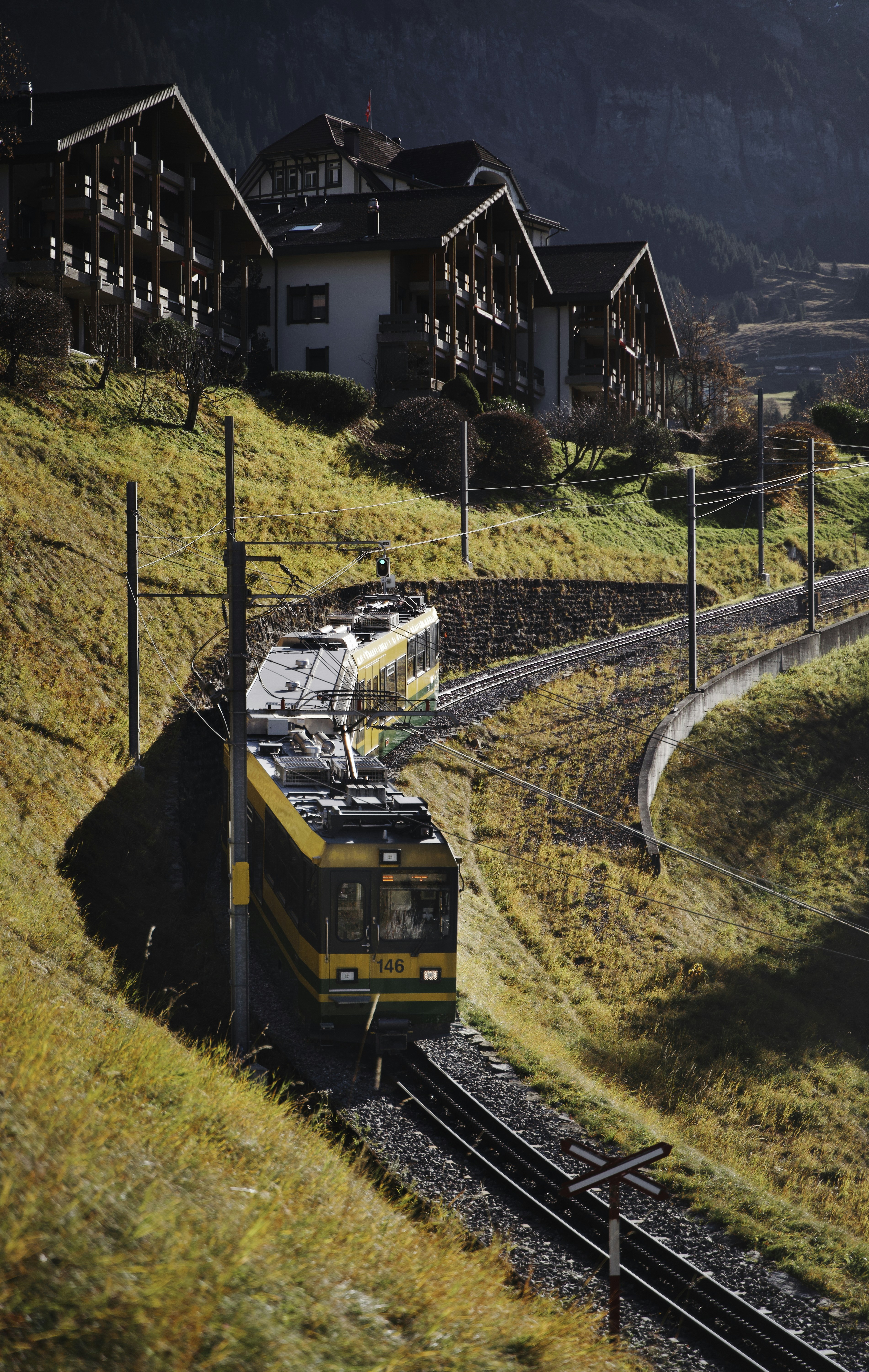 Alpine Switchback: A Yellow Train Winds Through Sunlit Chalets