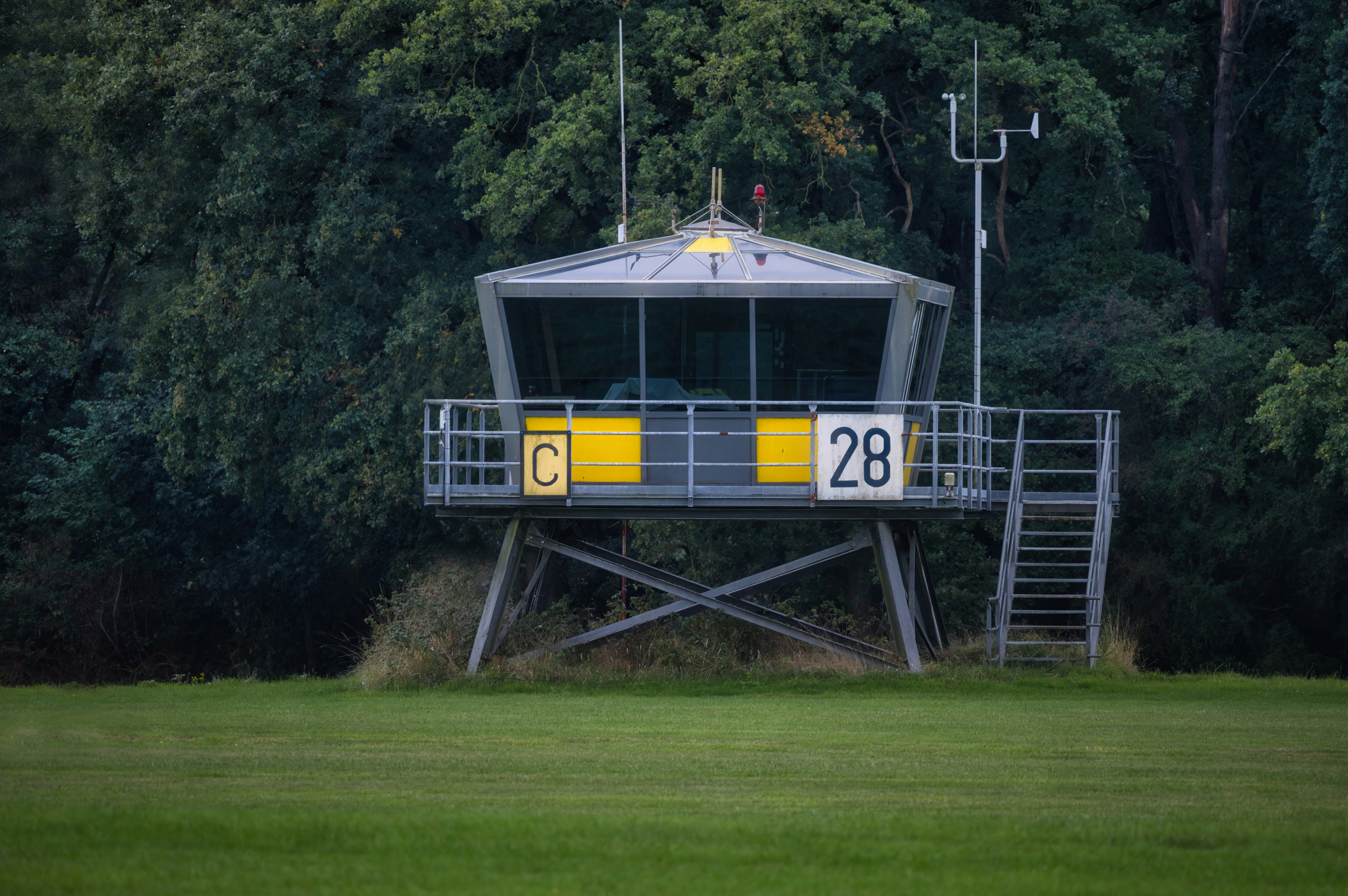 Air traffic control tower with yellow markings and number 28 photo ...