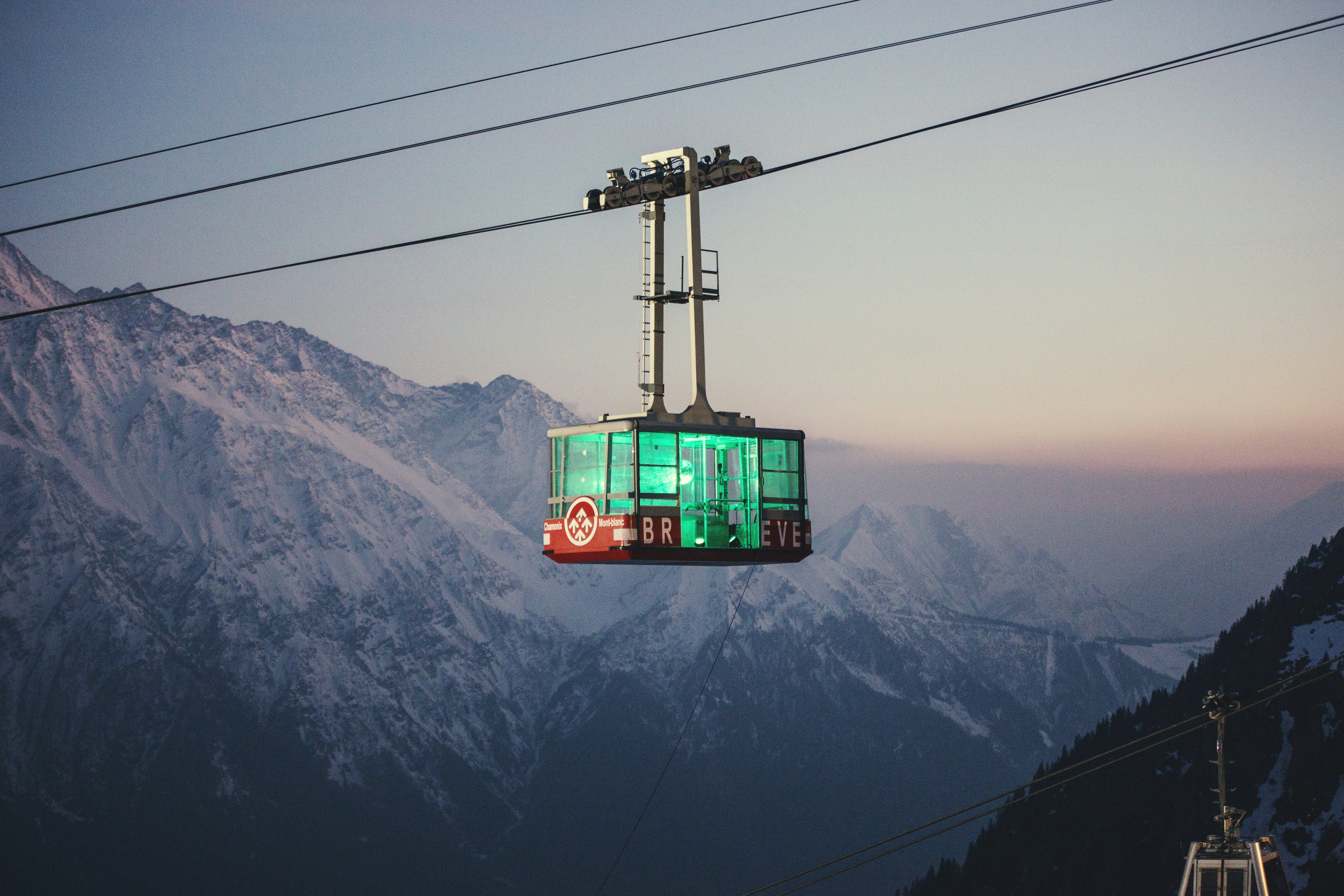 Gliding Through Twilight: Cable Car Over Frosted Alps