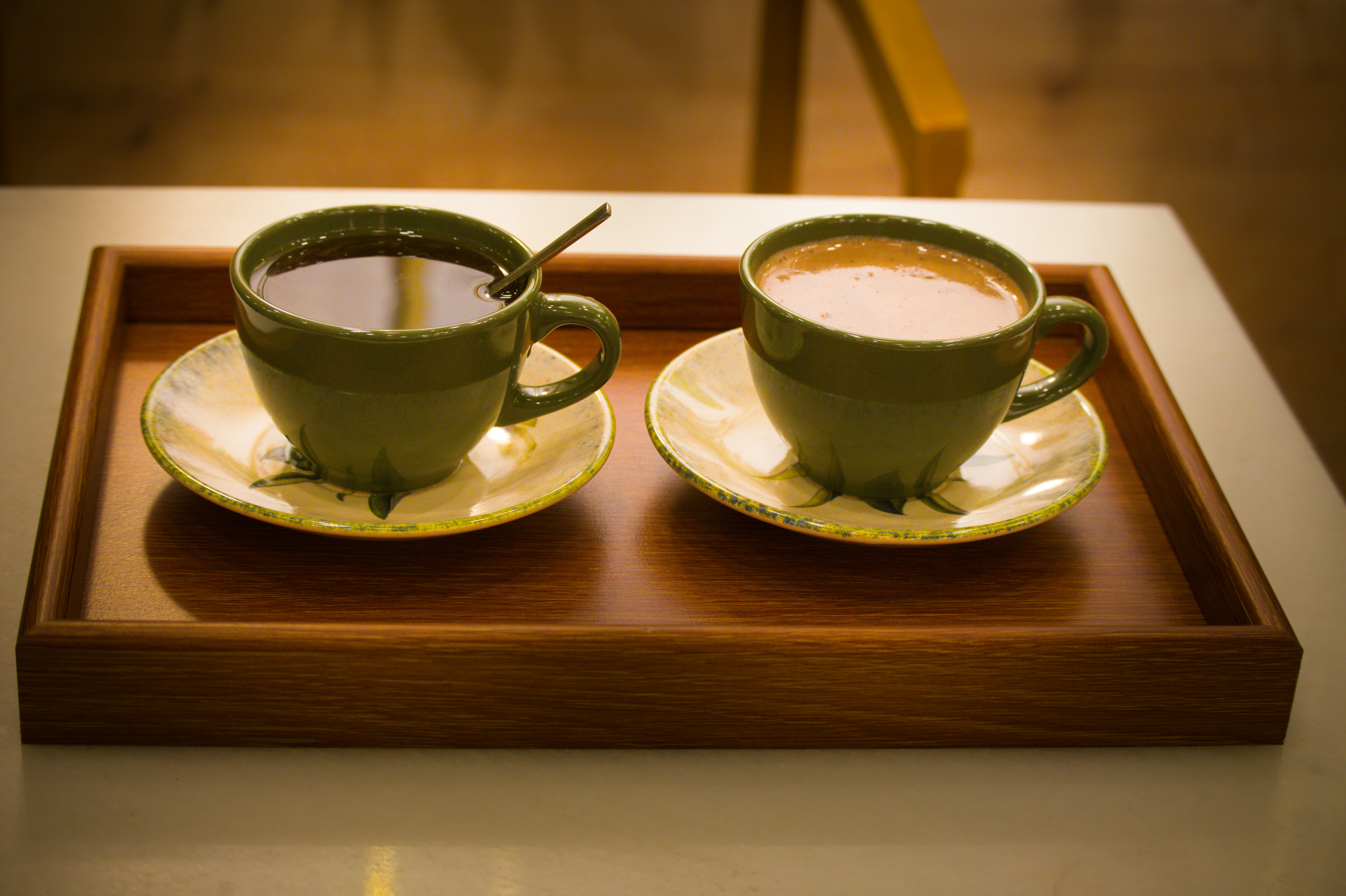 Foam and Dark Brew: Two Coffees Resting on a Wooden Tray
