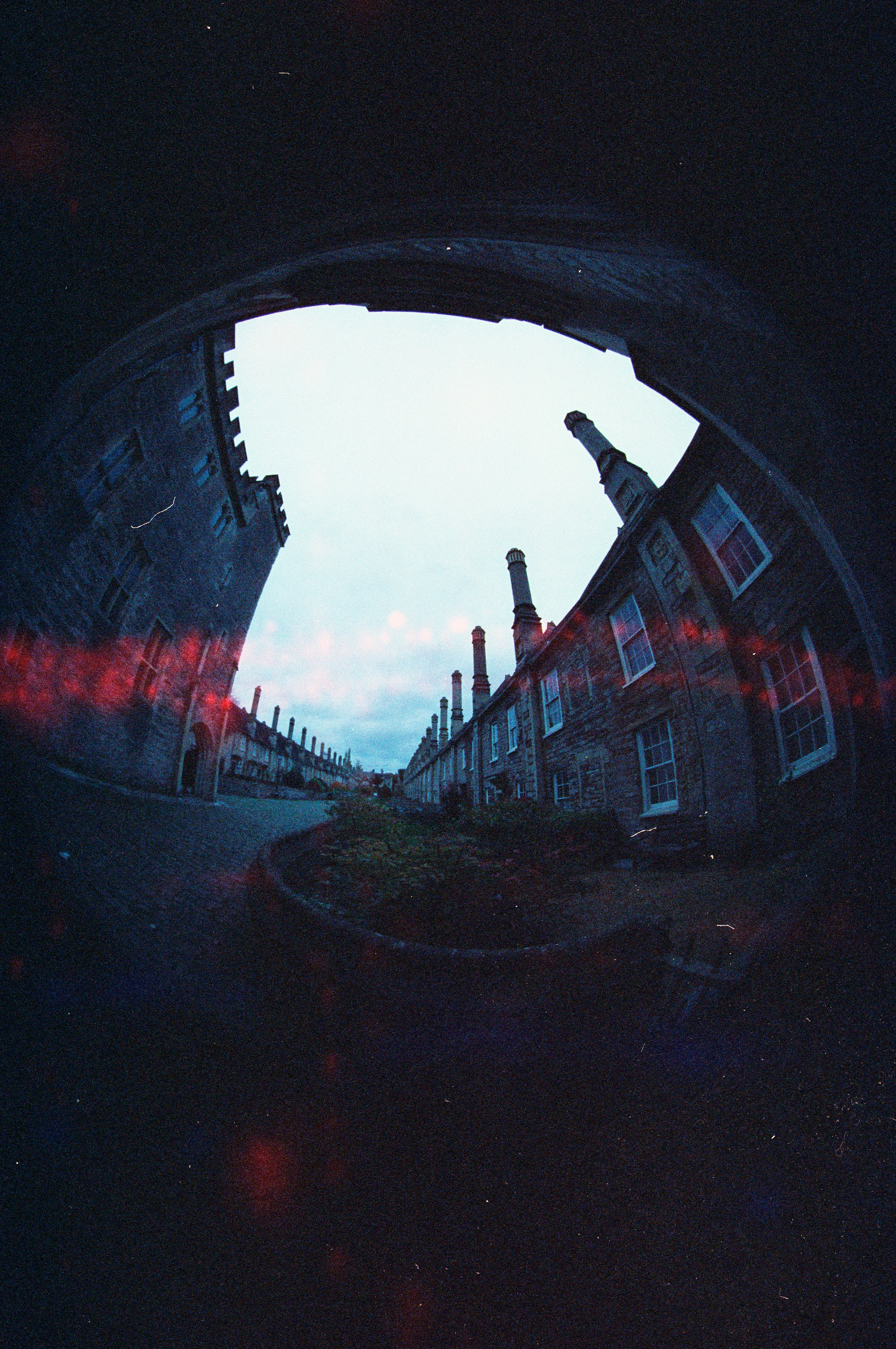 Row of old stone houses with chimneys under sky.