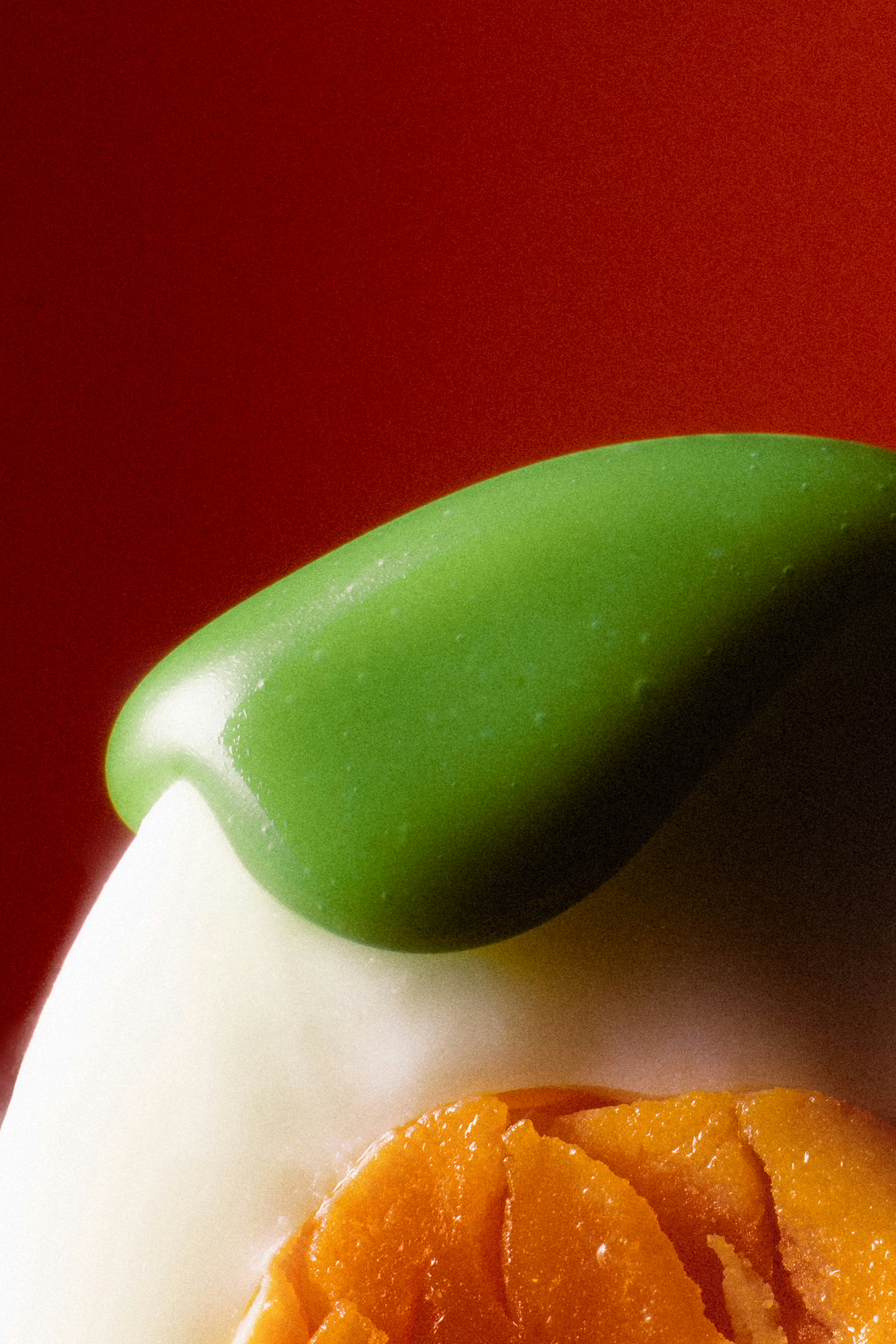 Glossy Green Bell Pepper Cap Against a Fiery Red Backdrop