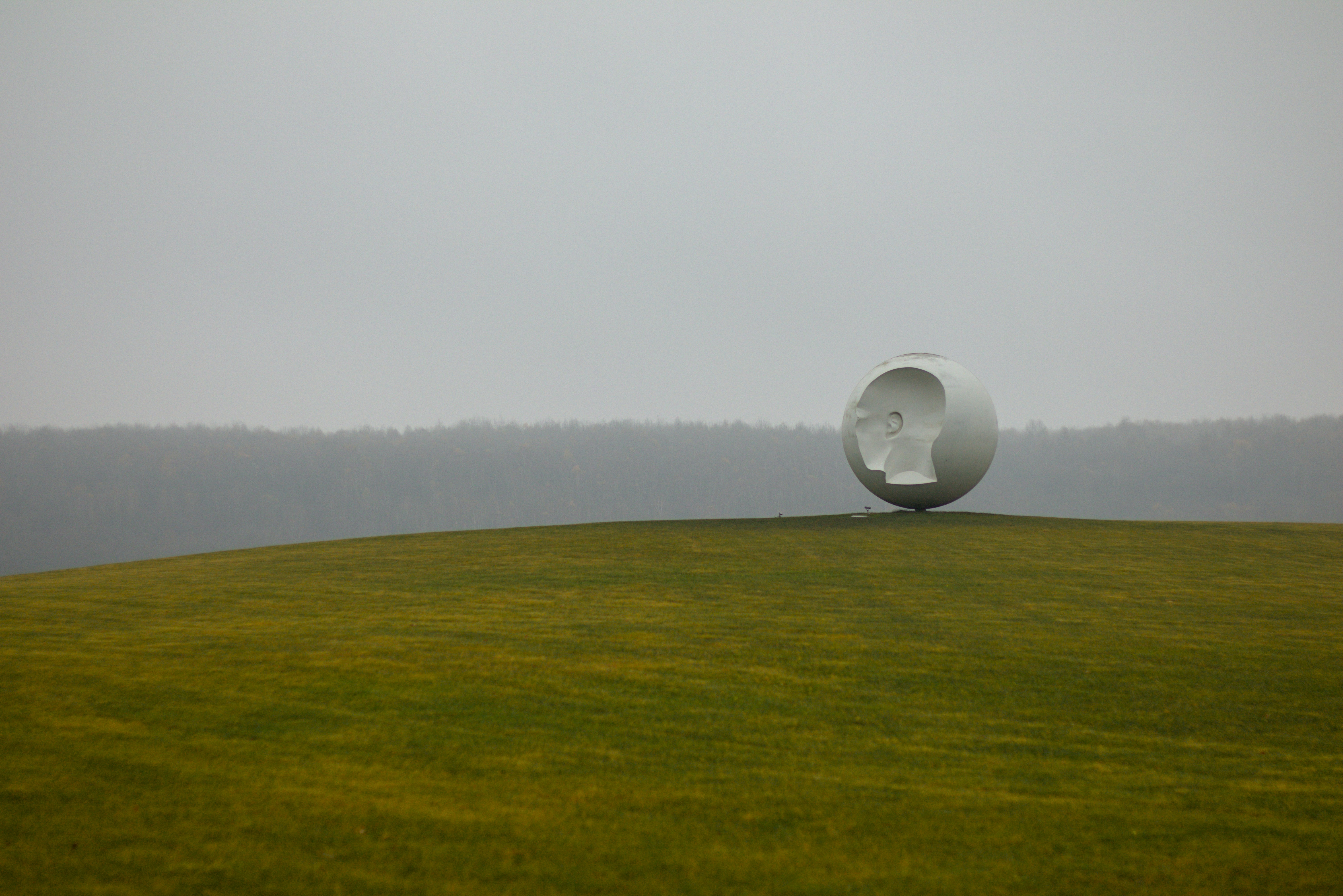 Circle on the Hill: A solitary white drum against a misty horizon