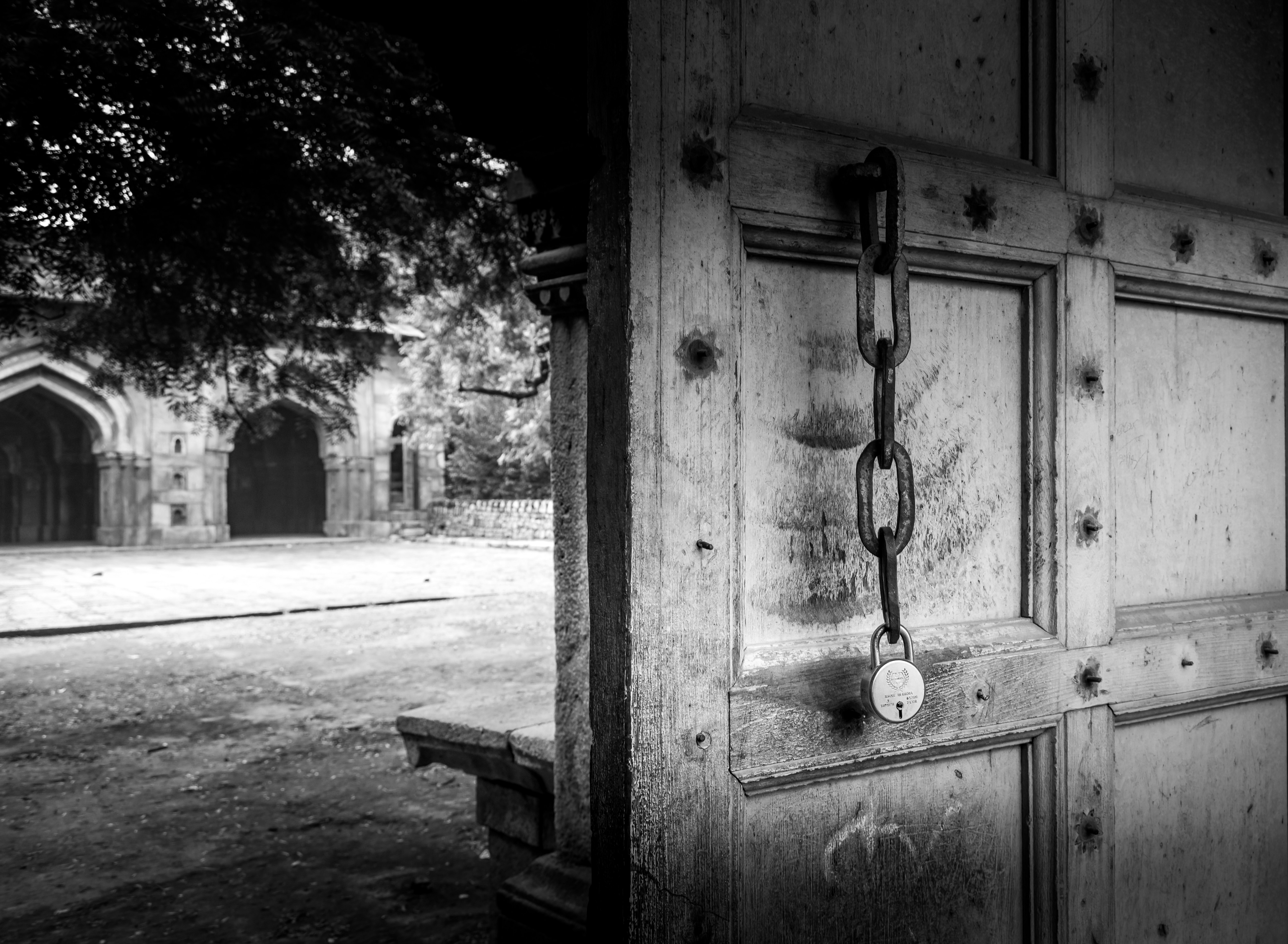Lock on the Threshold: Weathered Door and Chain in Monochrome