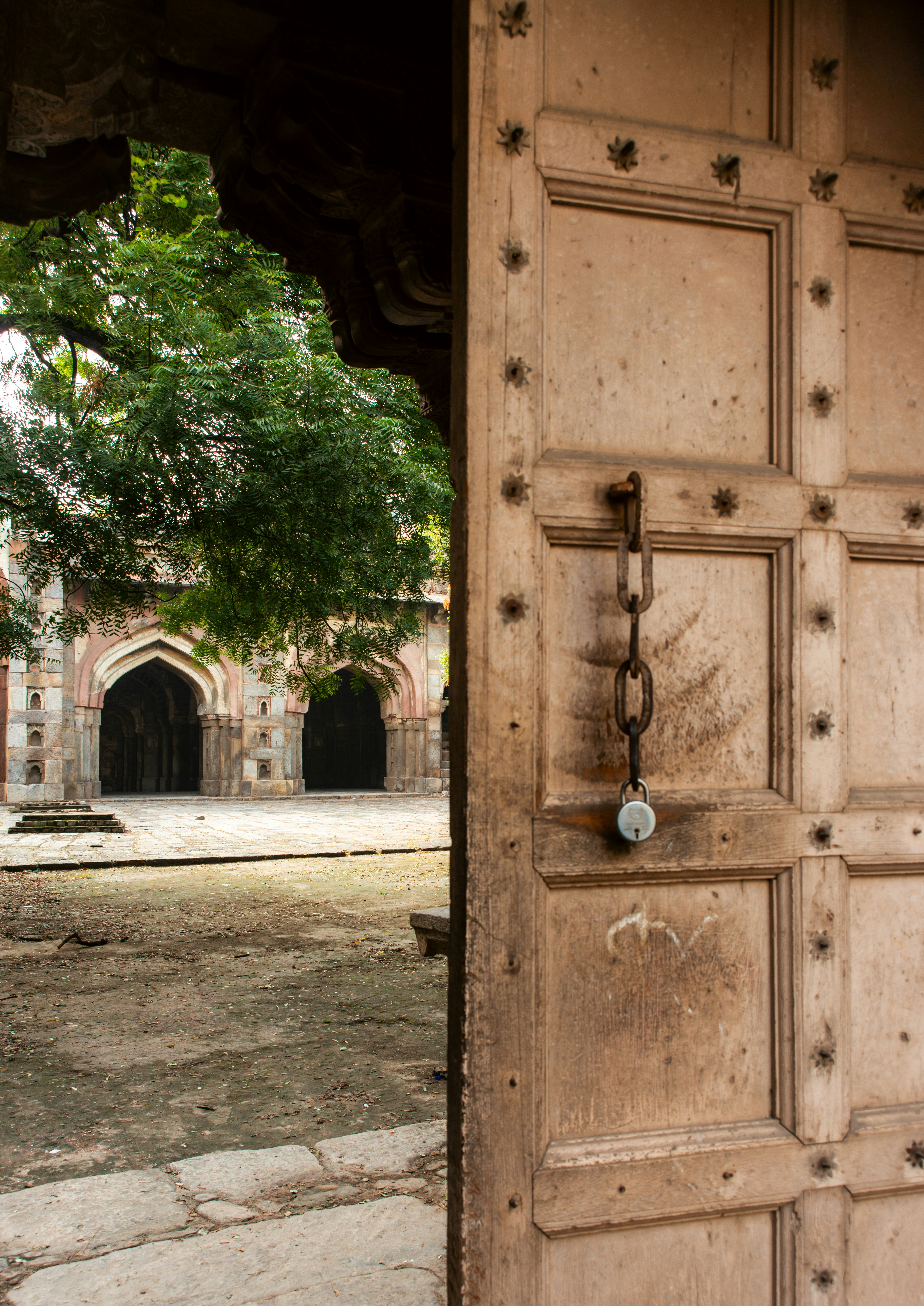 The Silent Lock: Weathered Wood Framing an Ancient Courtyard