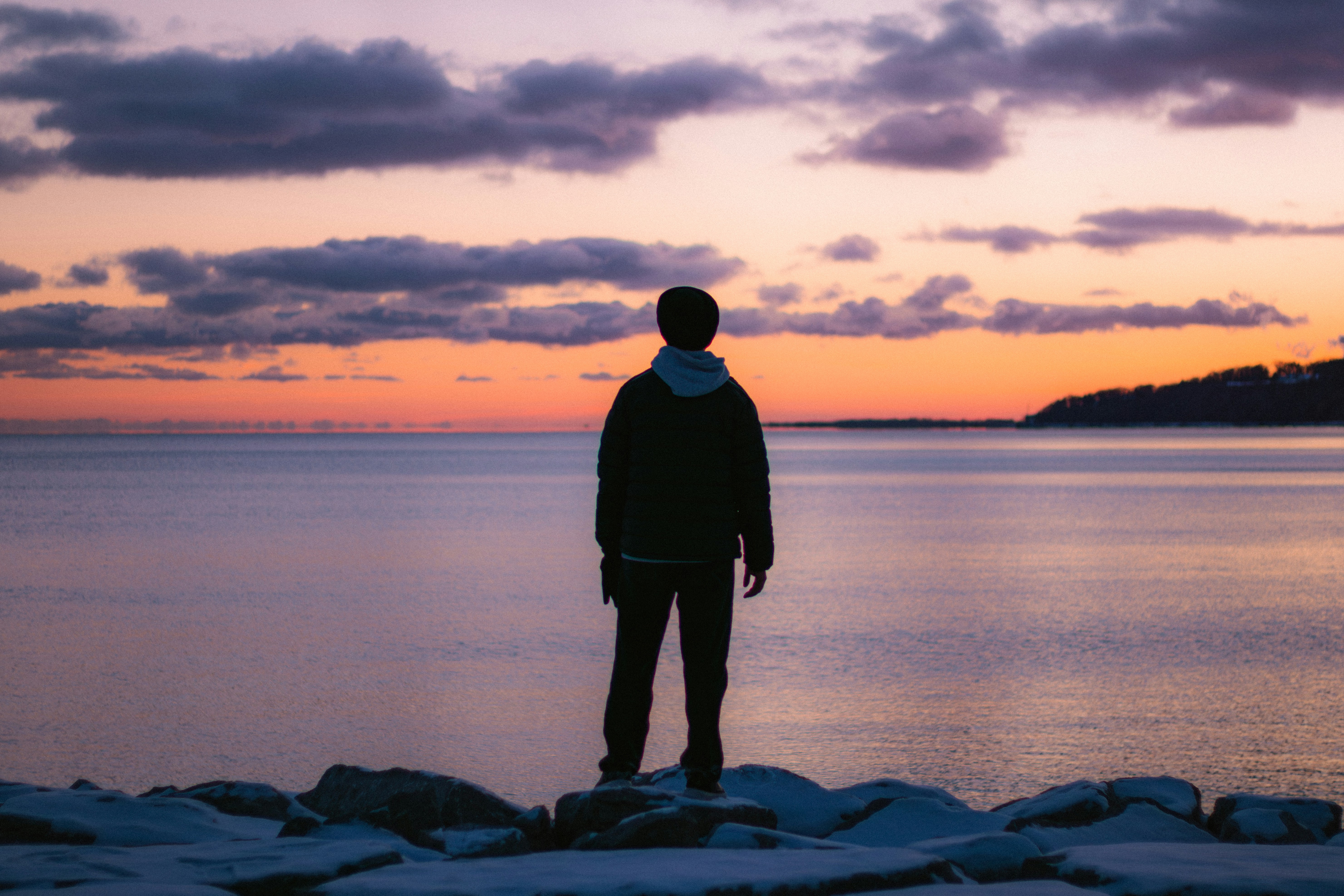 Person standing, watching the vibrant sky over Lake Ontario