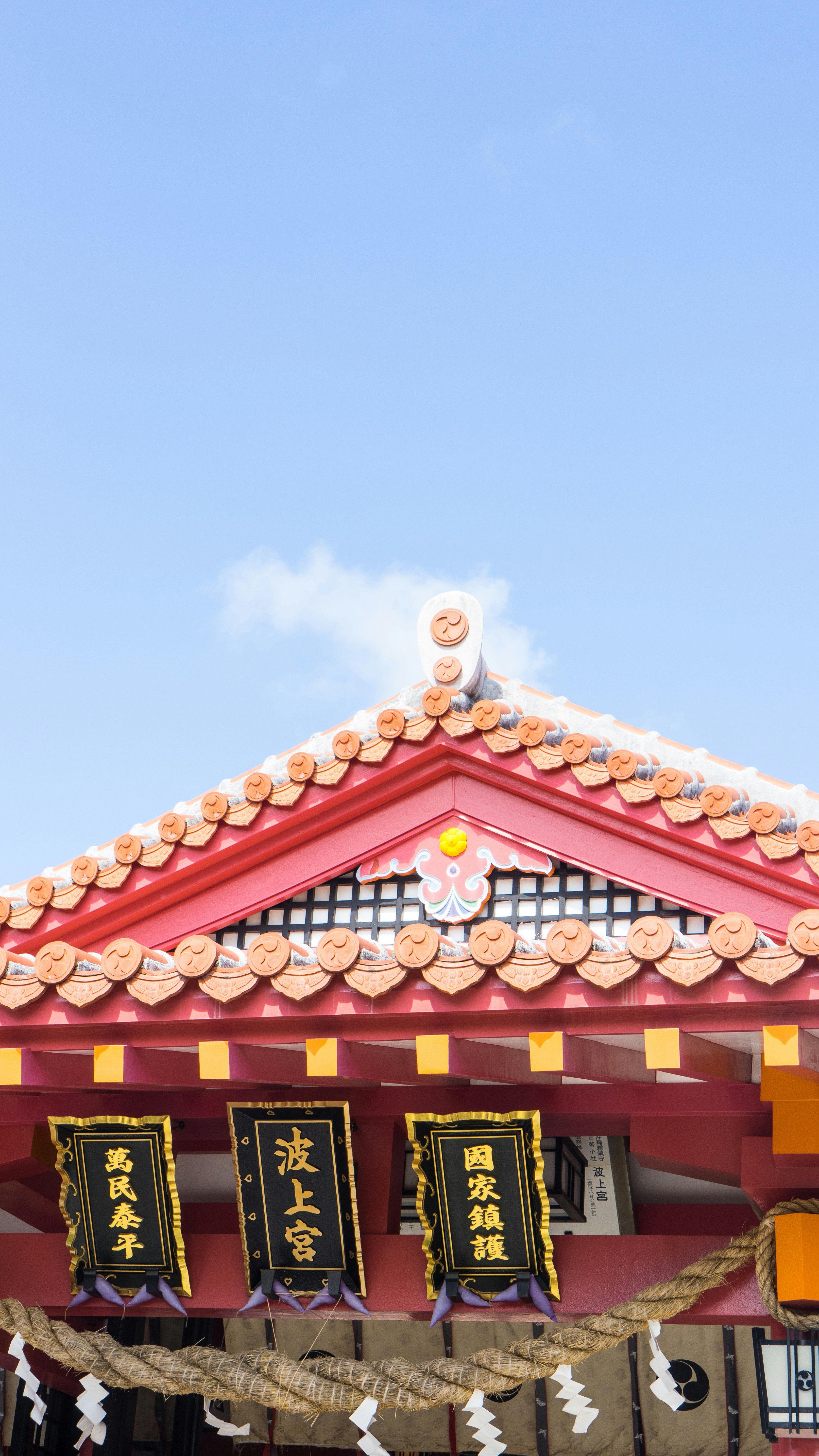 Sunlit Shinto Shrine Roof: Gold Plaques, Red Beams, and the Shimenawa