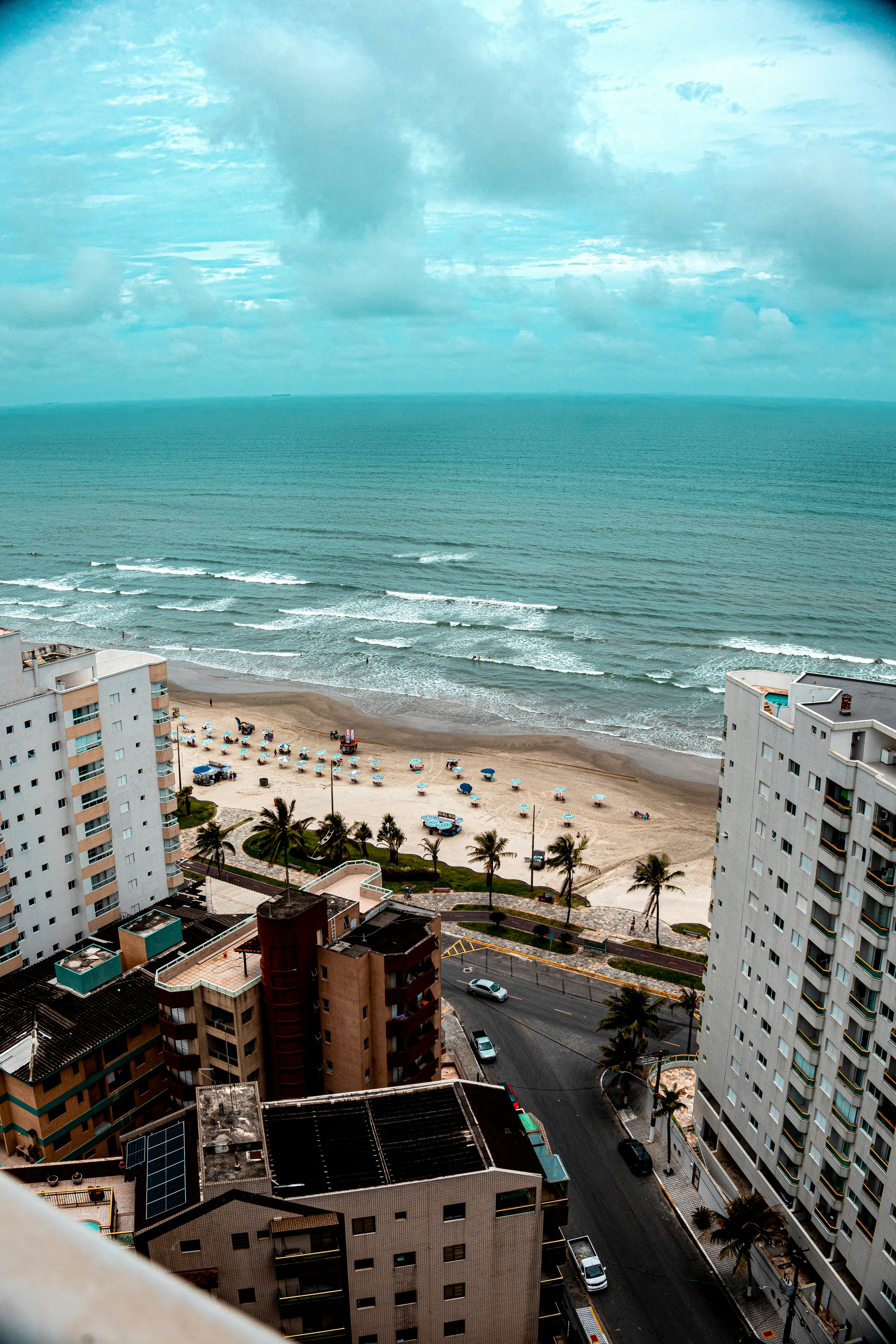 Aerial view of a serene coastal town with beach, ocean, and buildings.
