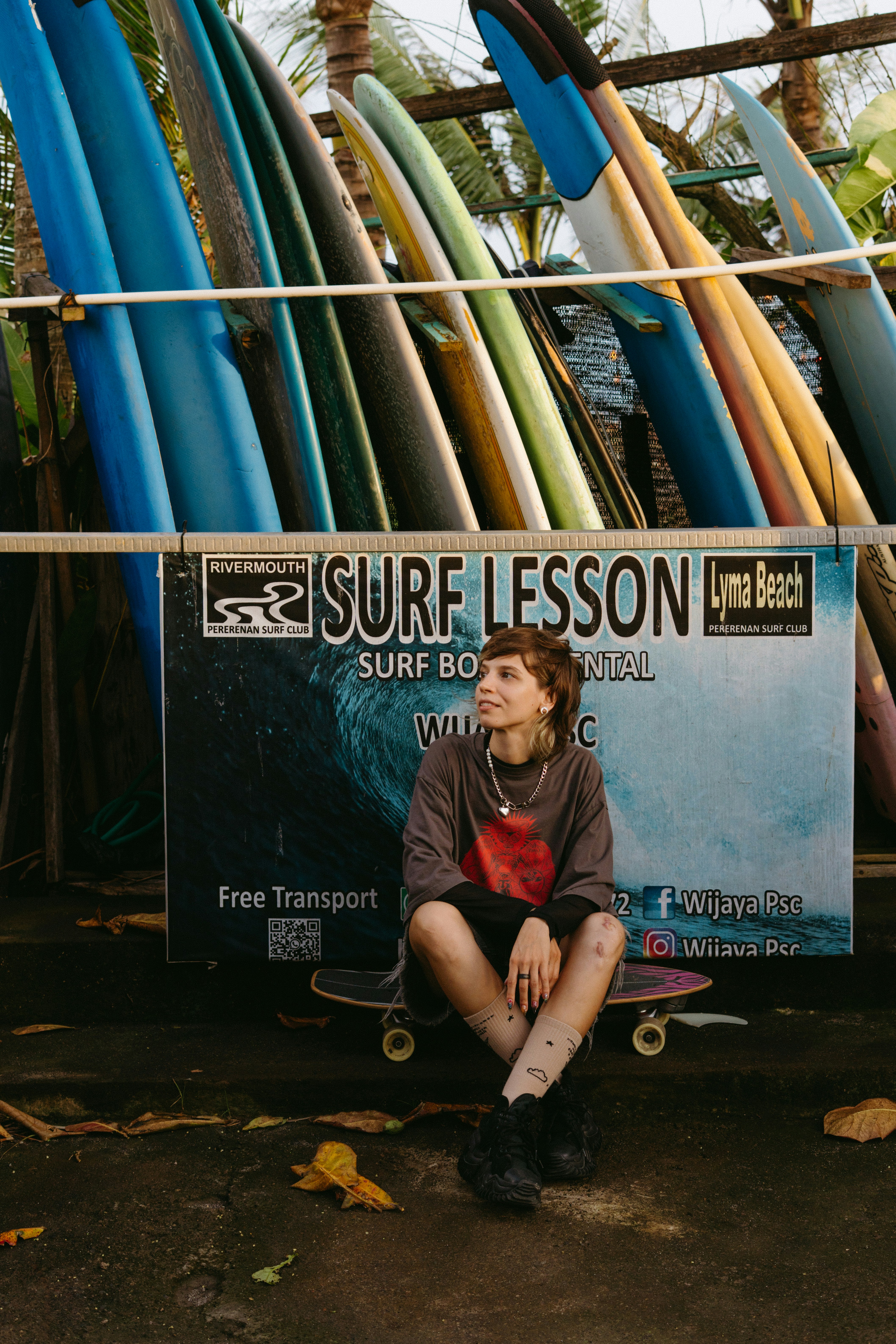 Portrait by the Surf Lesson Sign: A Quiet Moment Among Rainbow Sticks