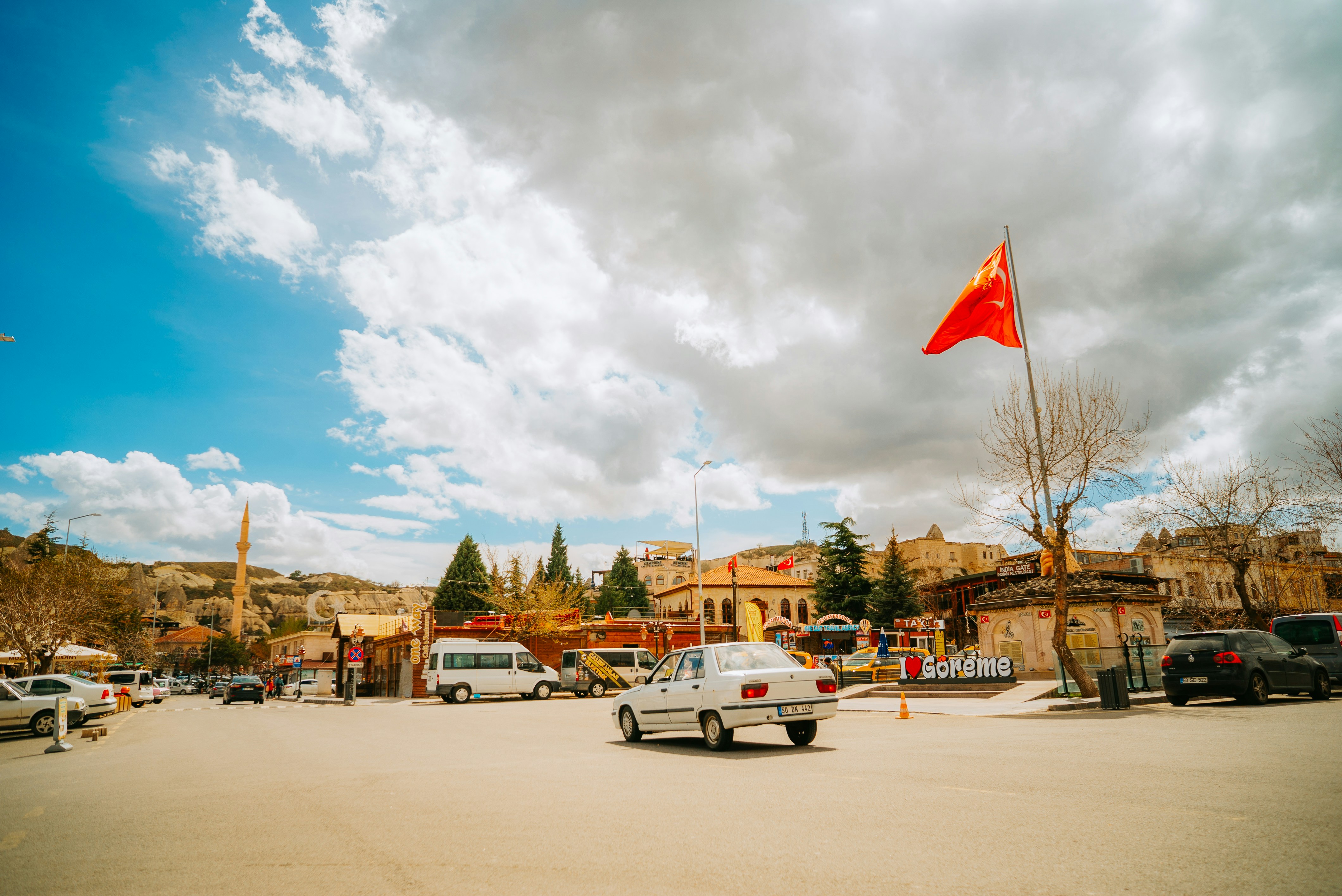 Red Flag Over a Sunlit Village Plaza