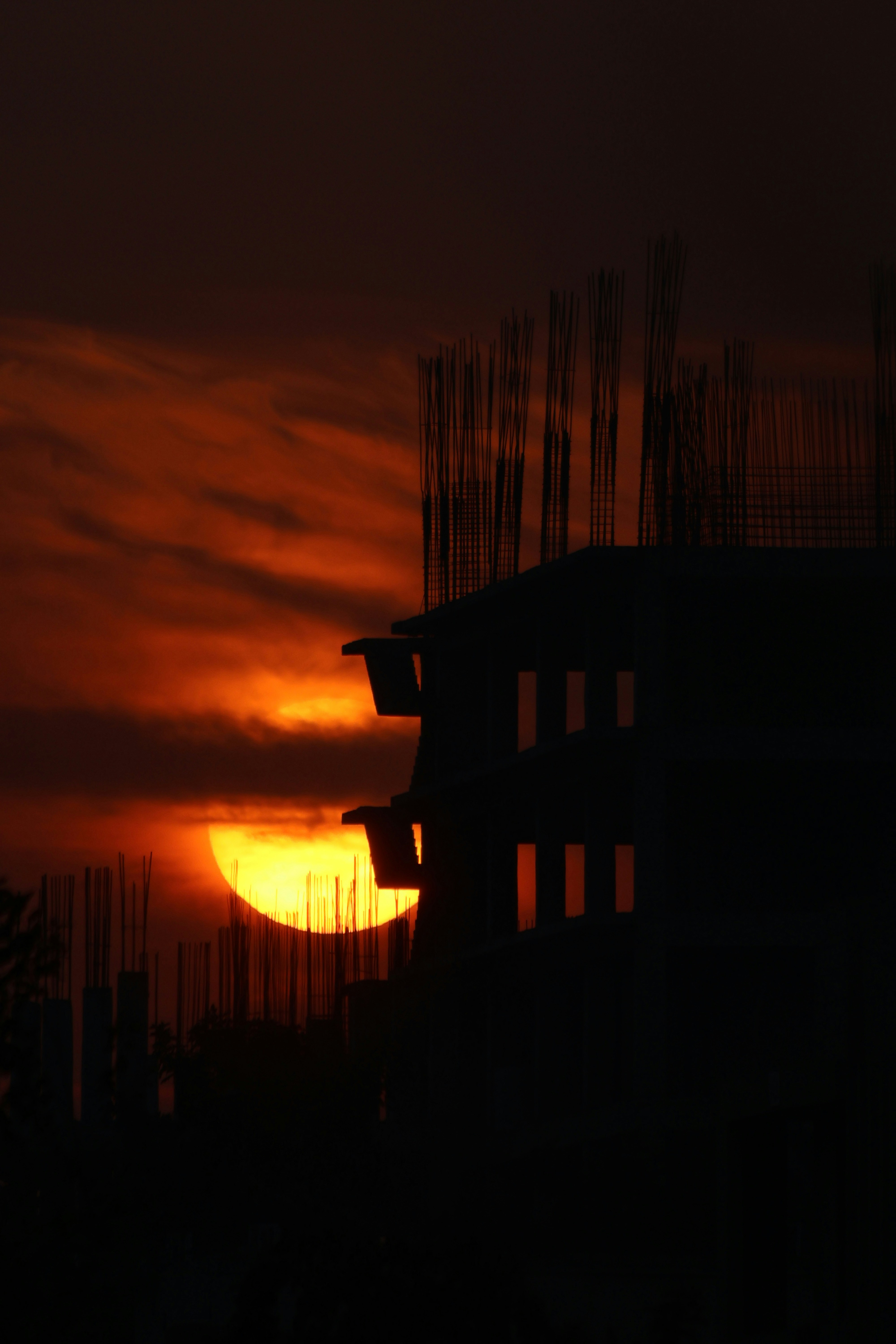 Sunset Behind a Rebar Skeleton: Dusk Silhouette at a Construction Site