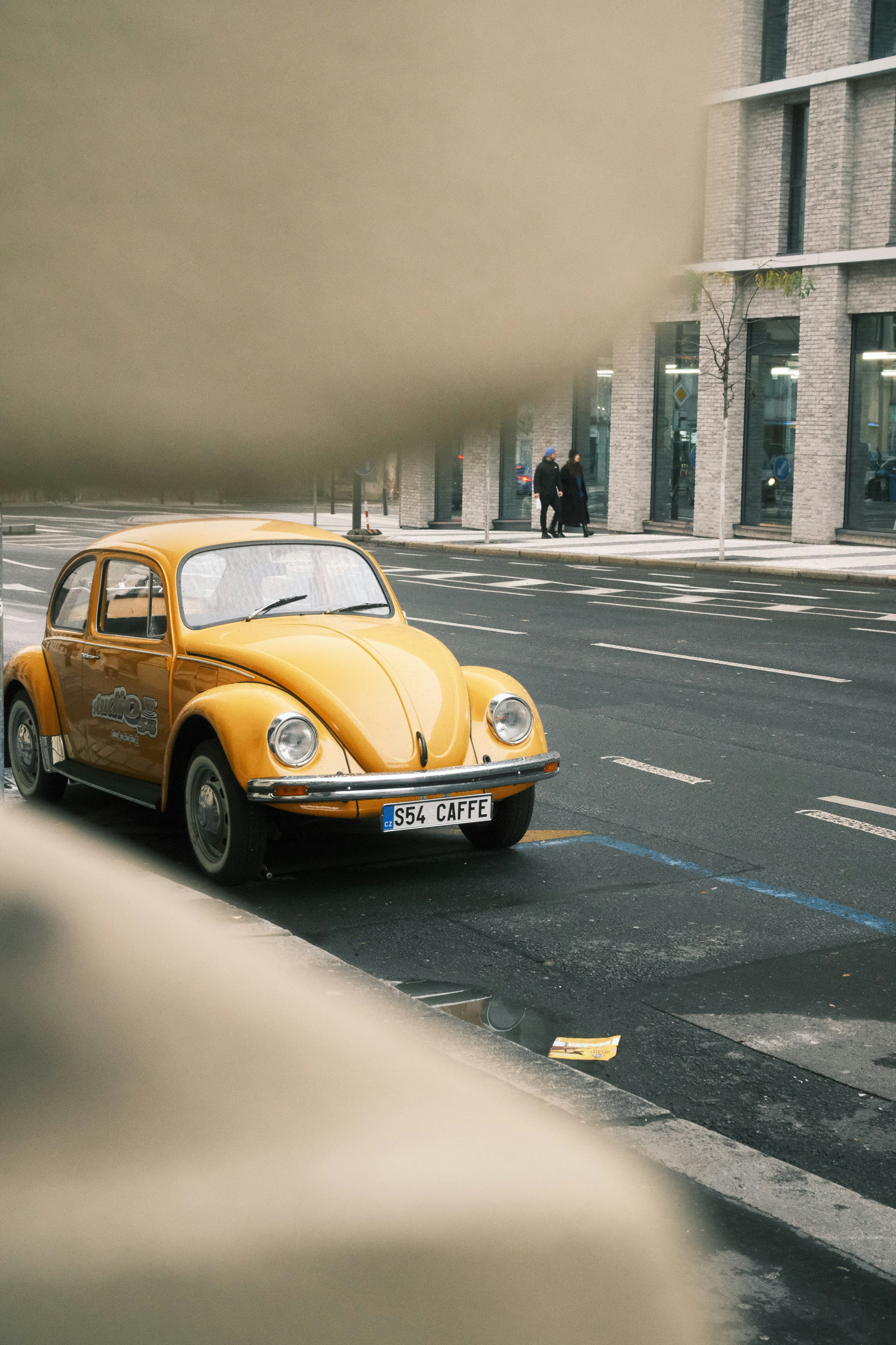Yellow Volkswagen Beetle parked on the street in urban setting