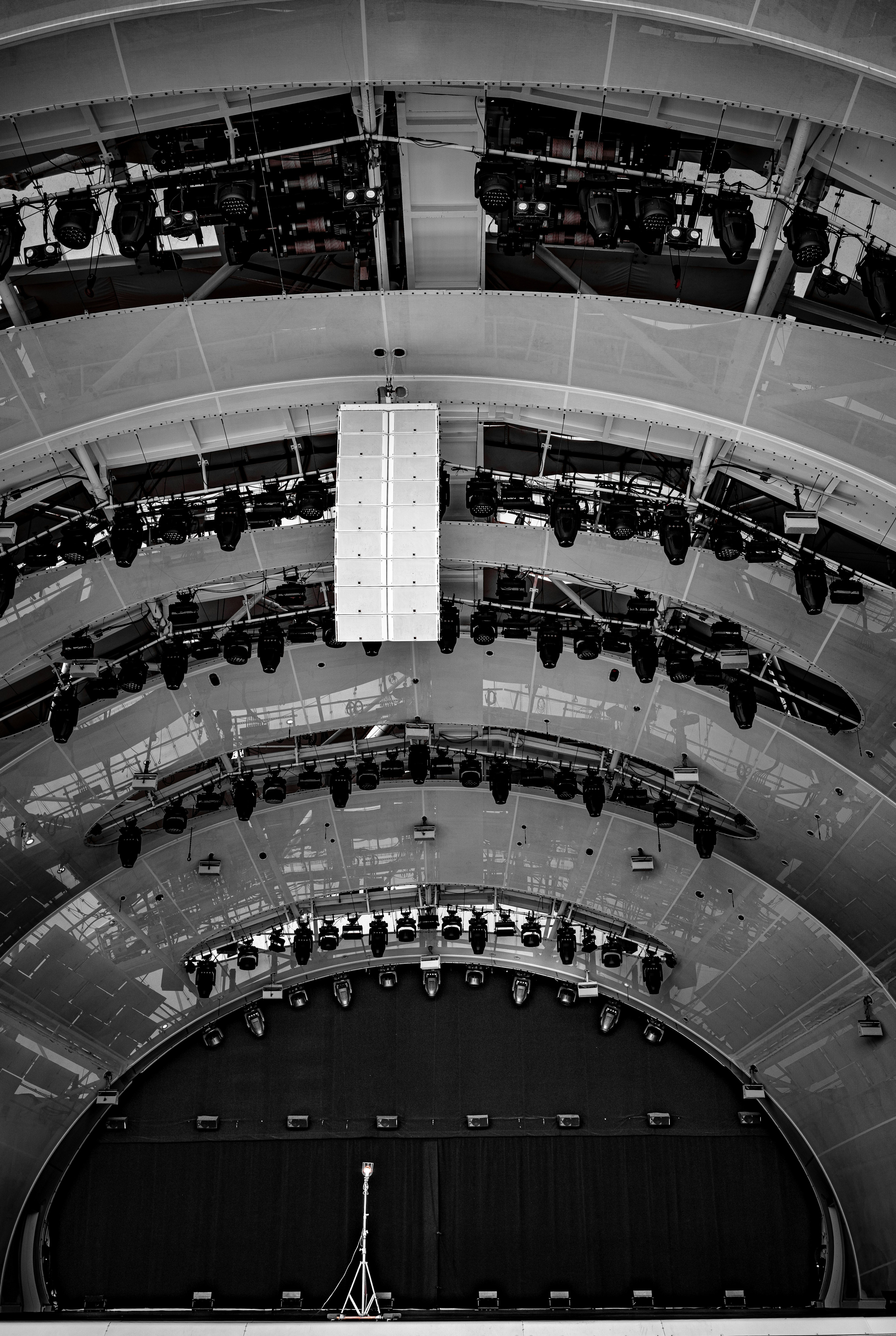 Stage lighting rig above an empty outdoor amphitheater stage