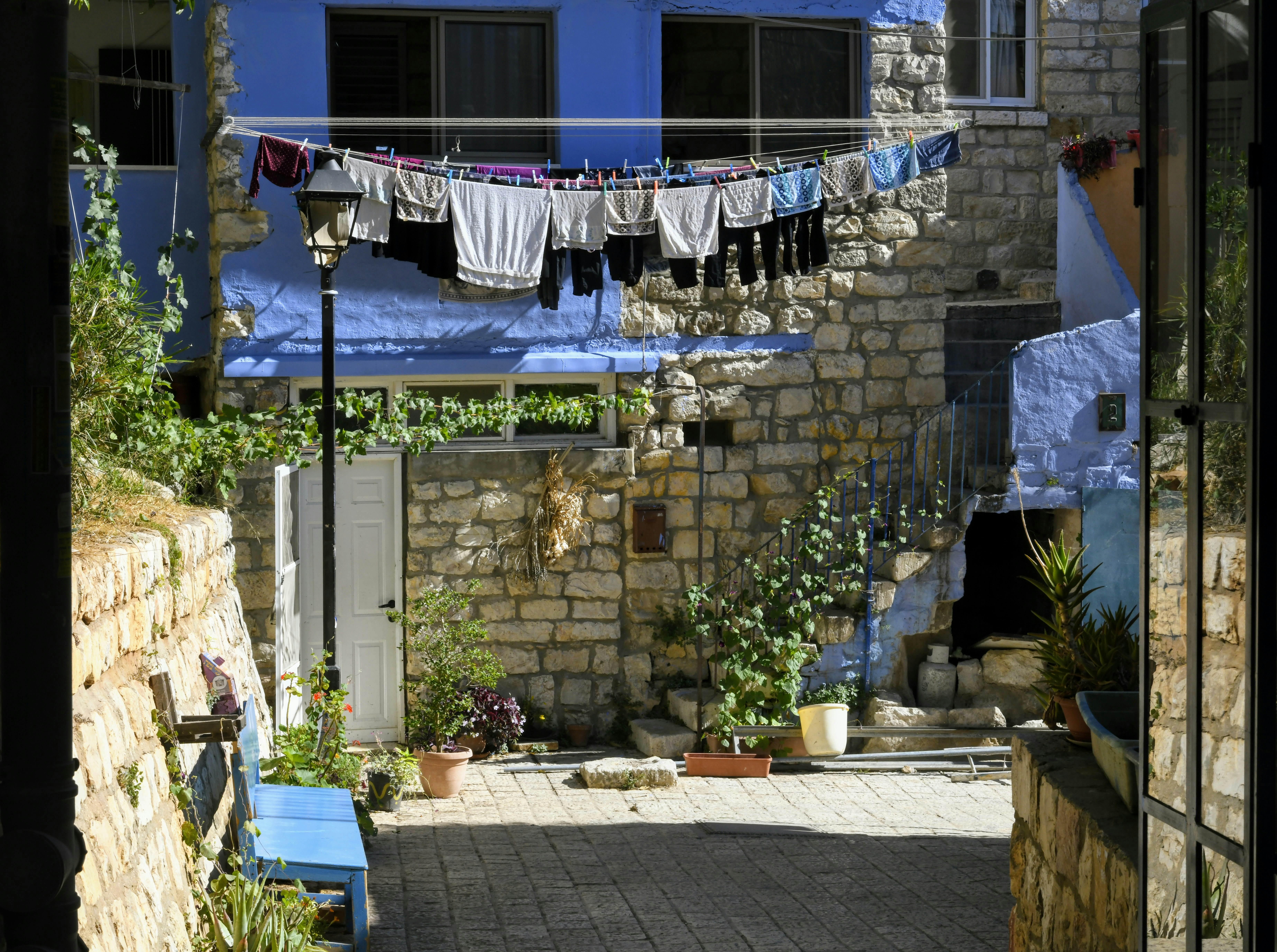 I was walking in a city and captured this shared courtyard with plants and stone buildings. It was neat and alluring wondering what the apartments looked like inside.