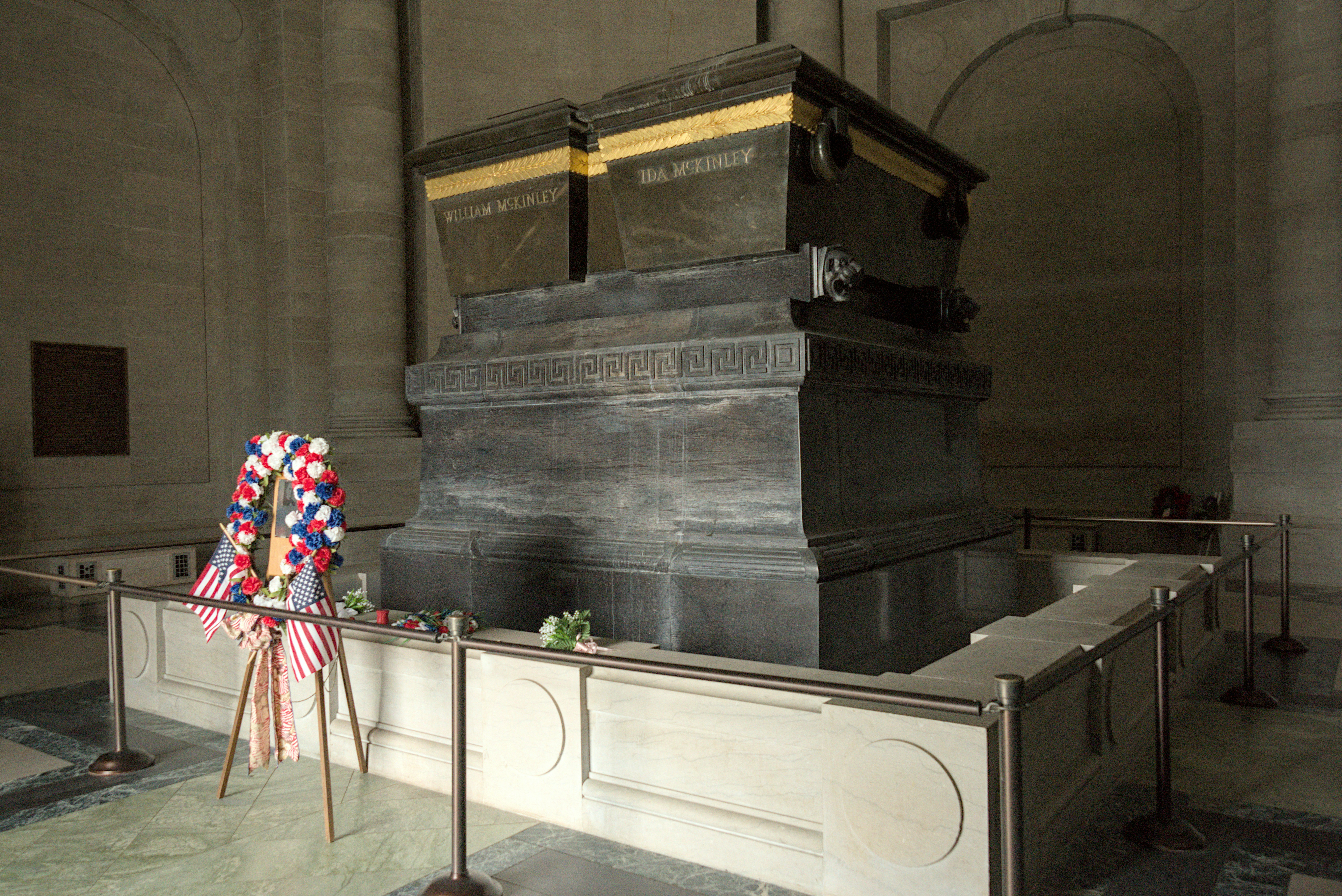 Stone Sentinel: Wreaths and Flags Beside a Marble Mausoleum