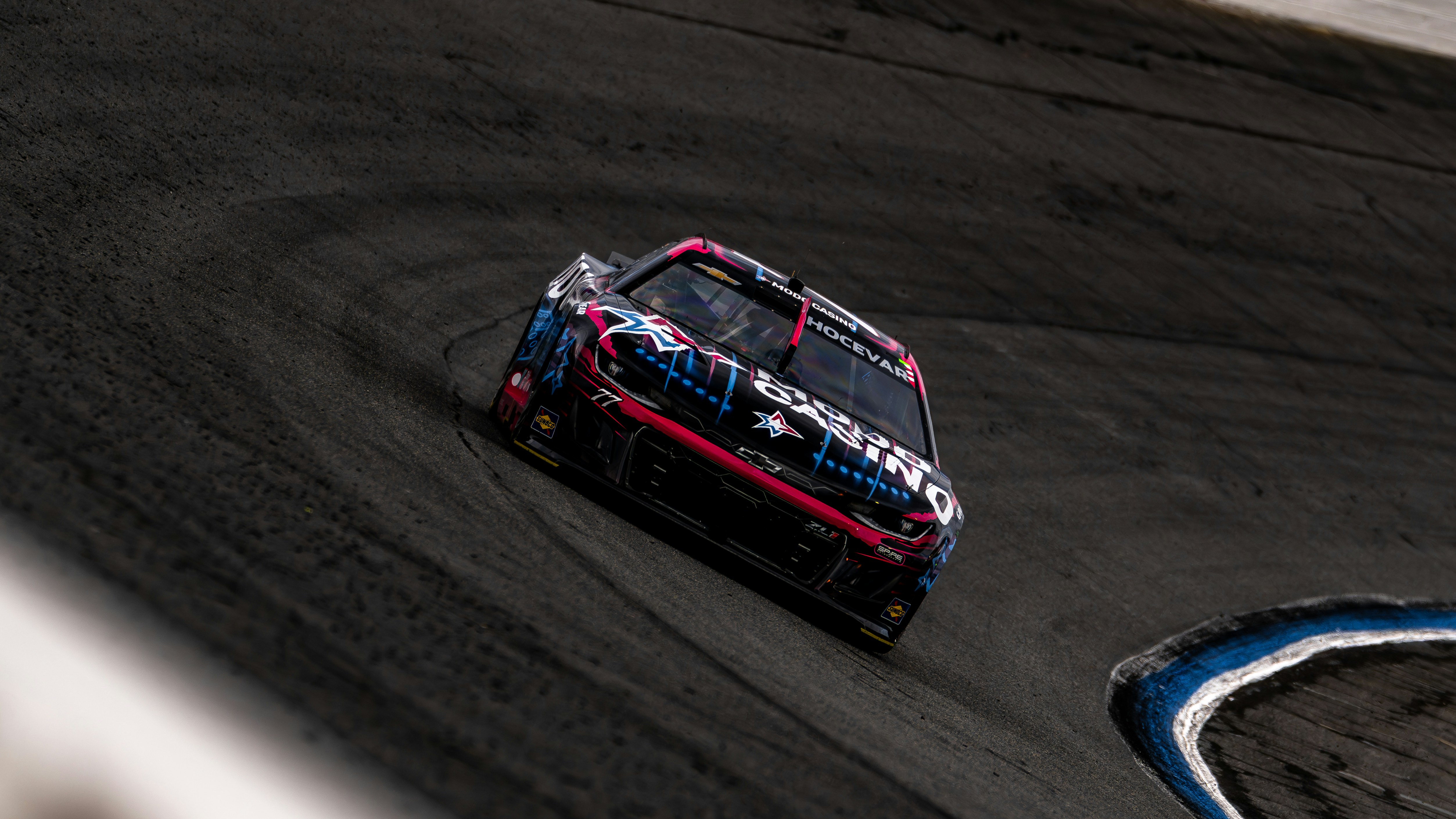 Arc of Speed: A racecar carving through a shadowed curve