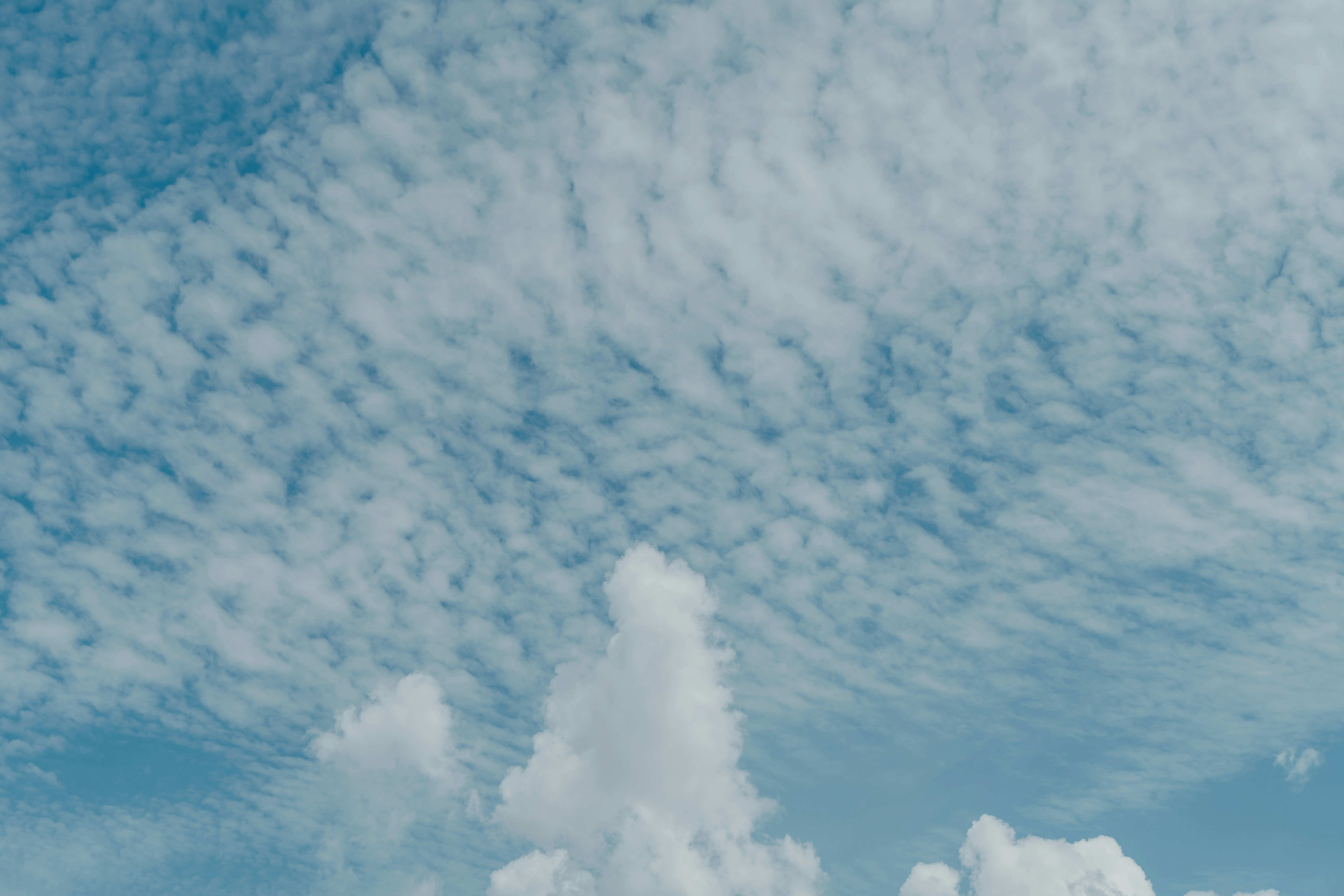 Pillared Cloudscape: Cirrus Veils Over a Crisp Blue Expanse