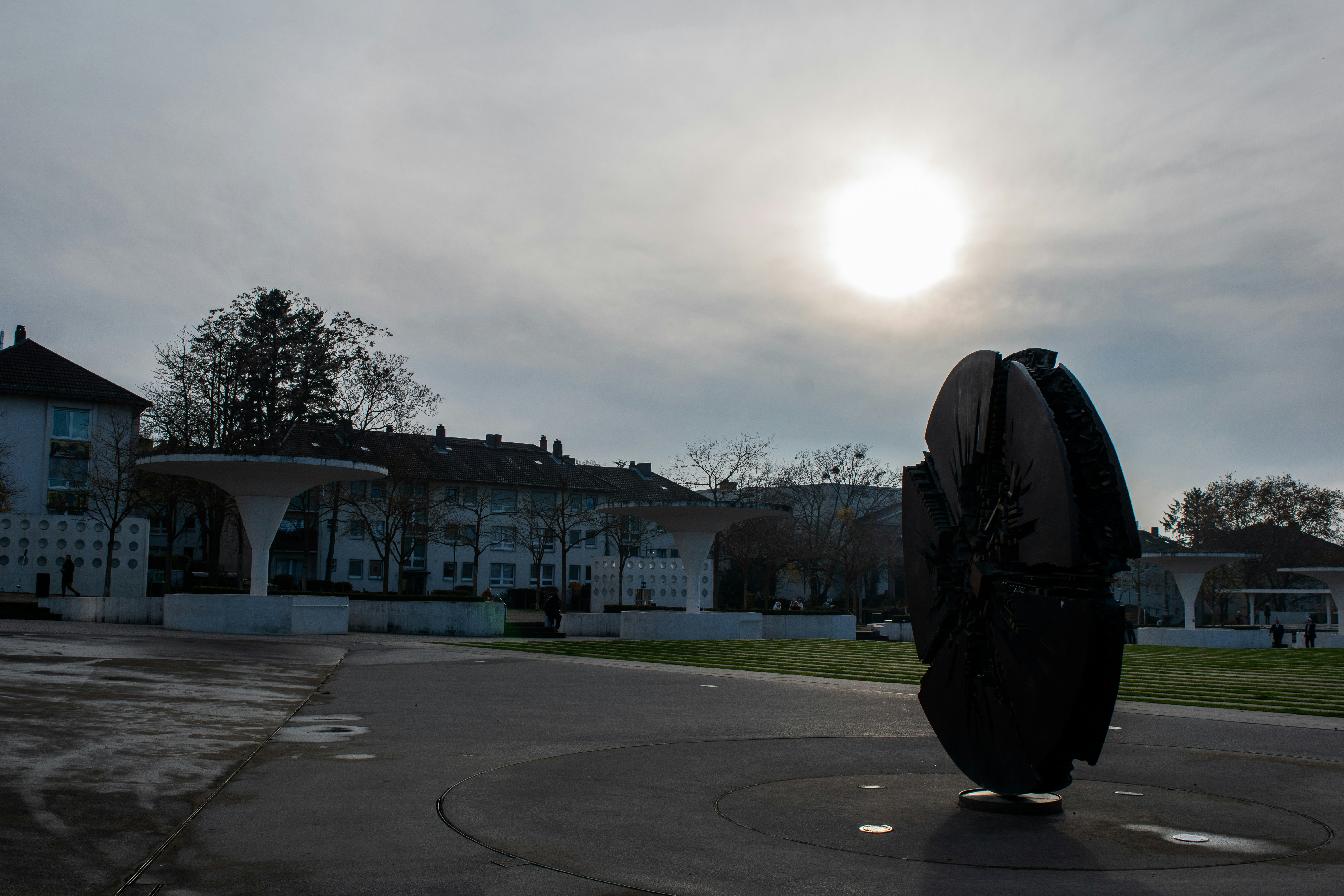 Iron Ring in the Quiet Campus Plaza: A Circular Sculpture Backlit by a Winter Sun
