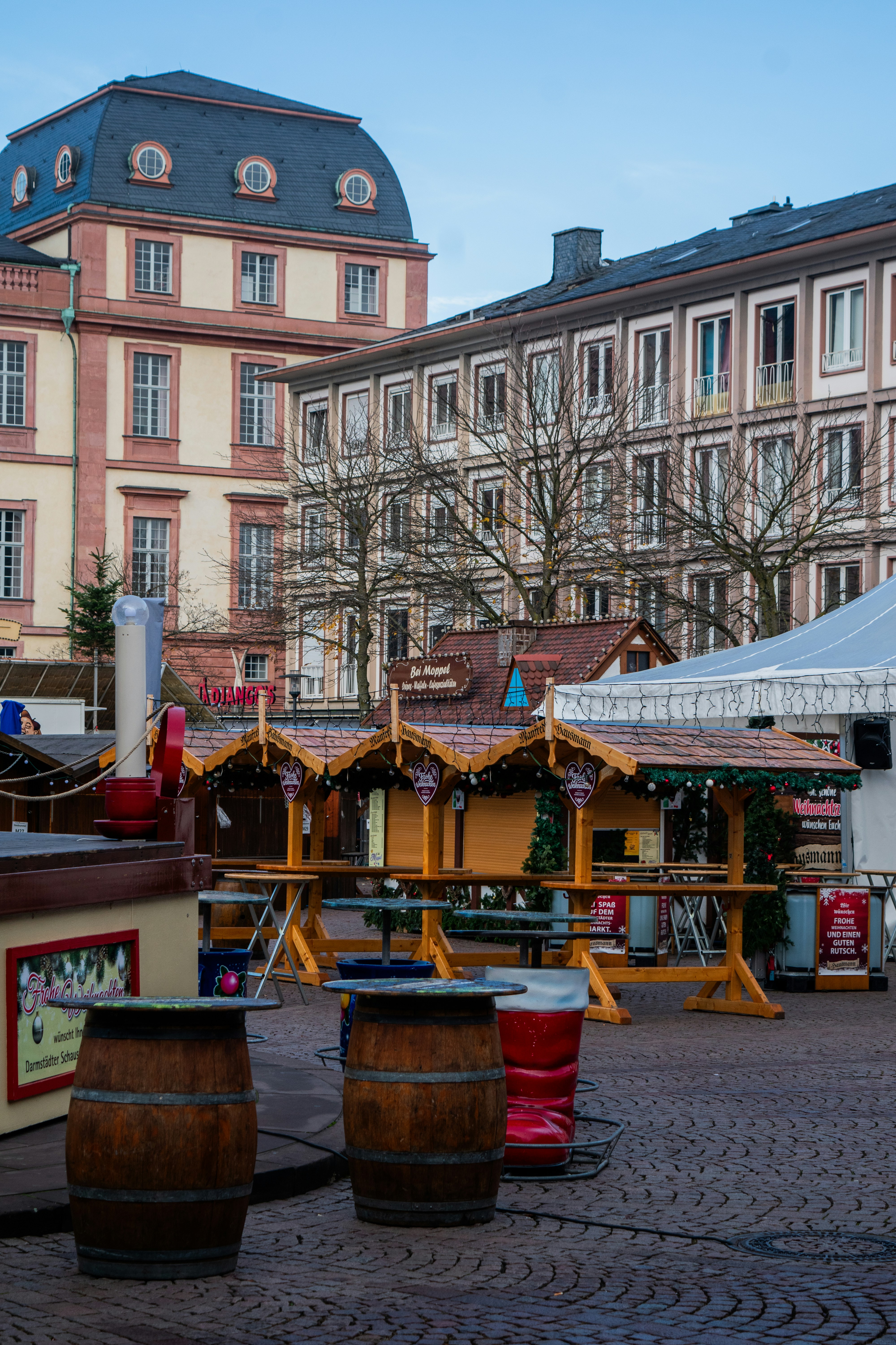 Pastel Facades Framing a Cobblestone Market with Wooden Stalls