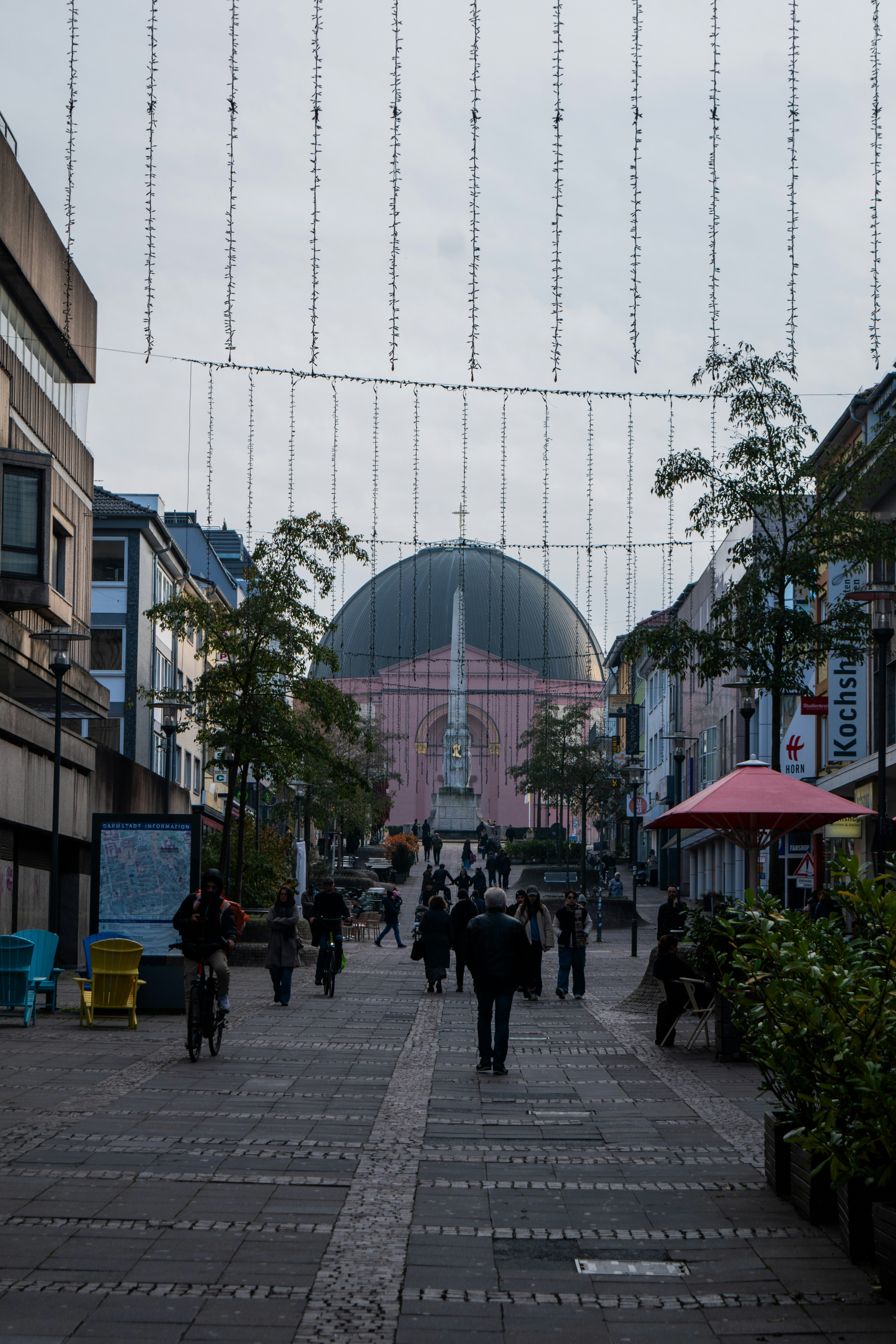 Pink-Domed Arch at the End of a Pedestrian Boulevard Framed by Hanging Lights