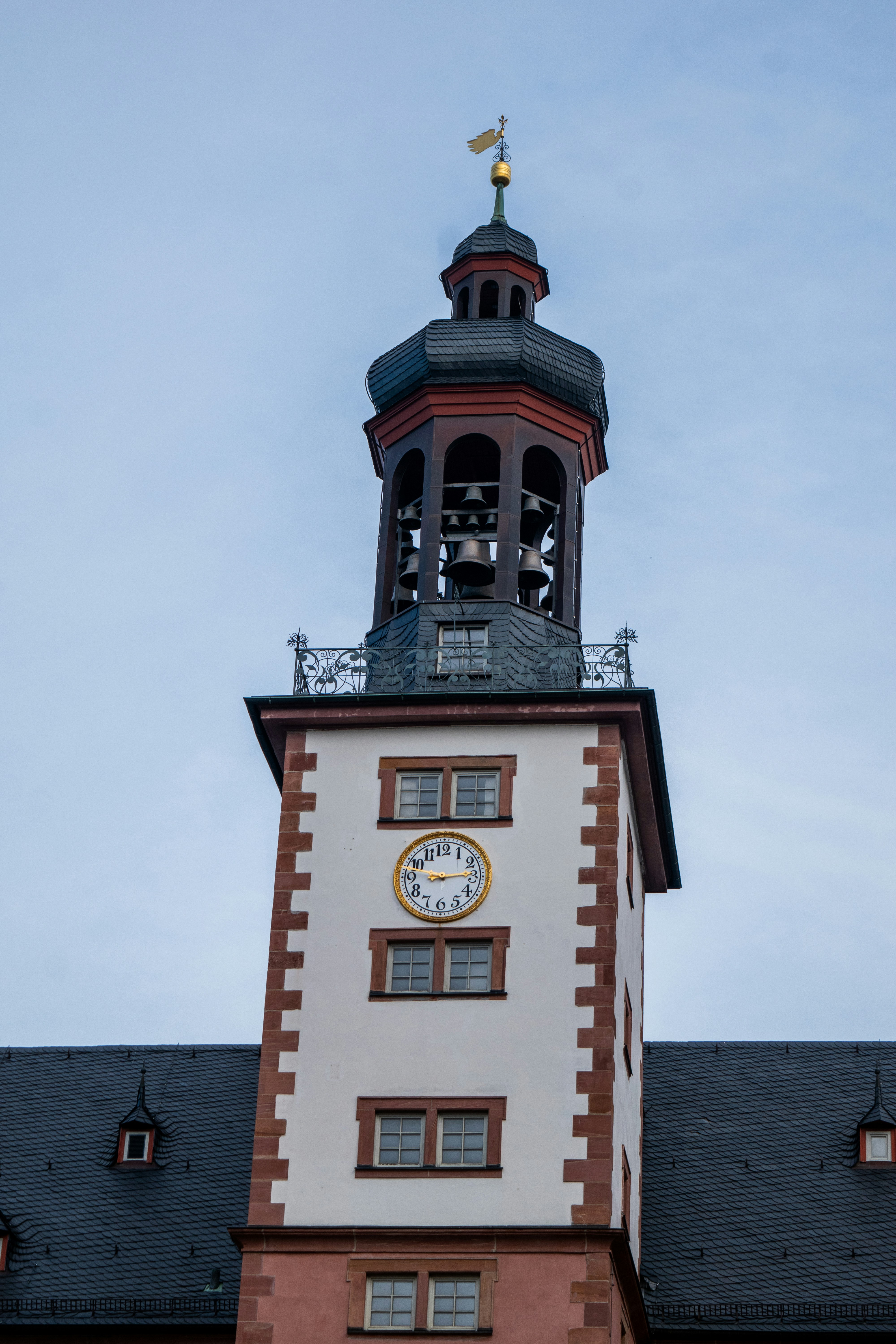 Clocktower Quietly Reaches Skyward Over Slate Rooftops