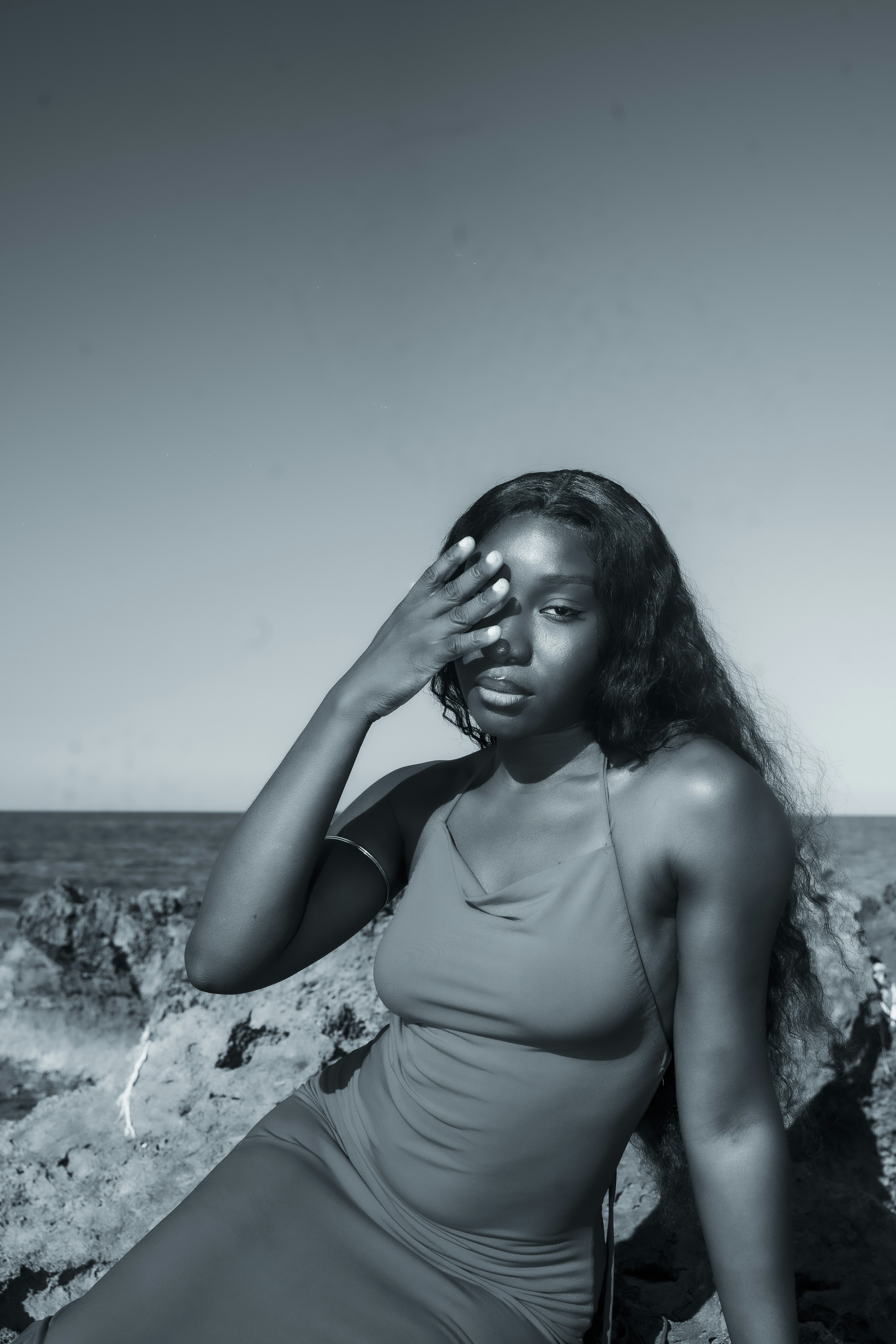 Coastal Quiet: A Mono Portrait Framed by Sea and Stone