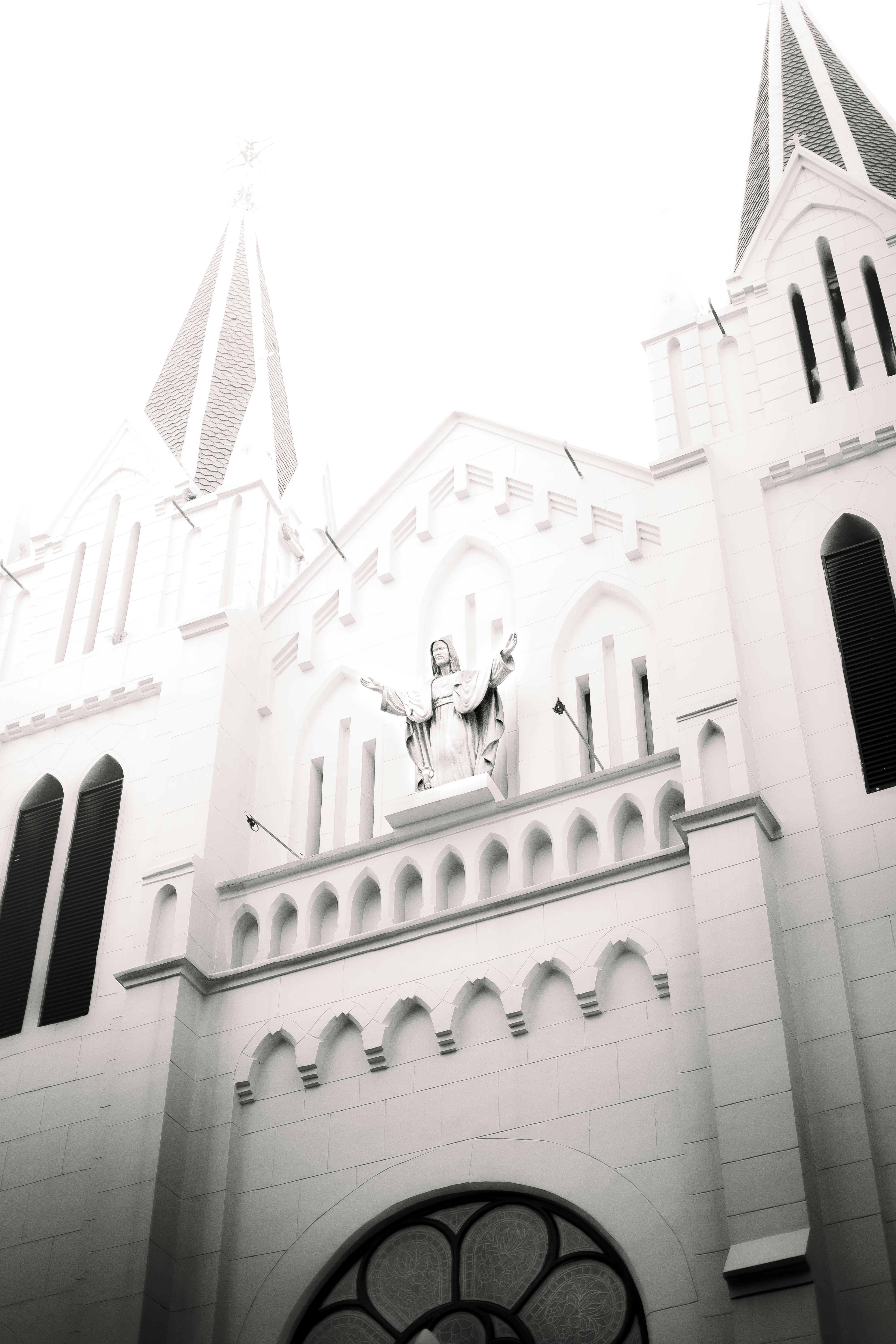 Statue at the Heart of a Sunlit White Gothic Facade