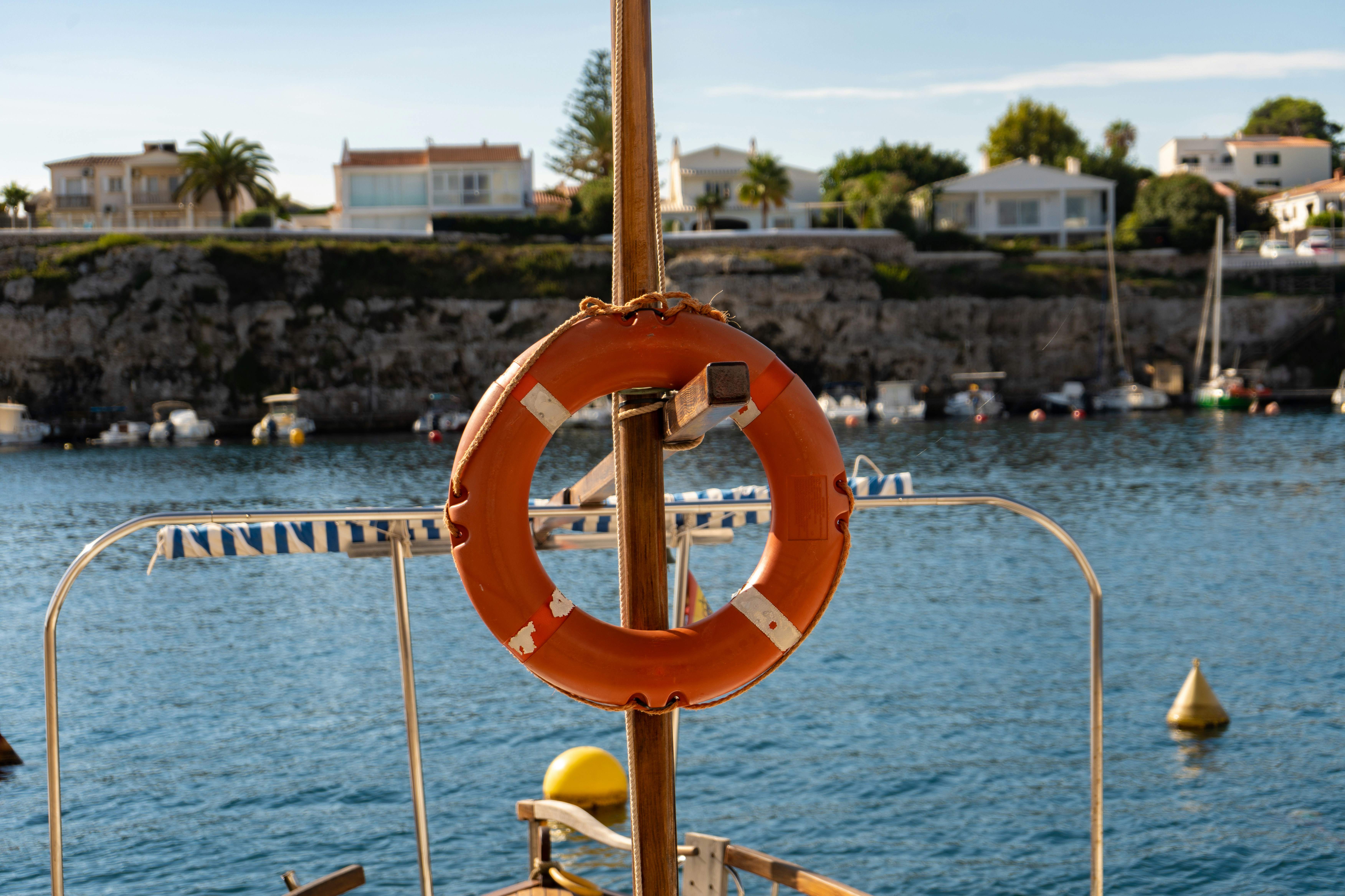 Lifebuoy sentinel over a sunlit harbor