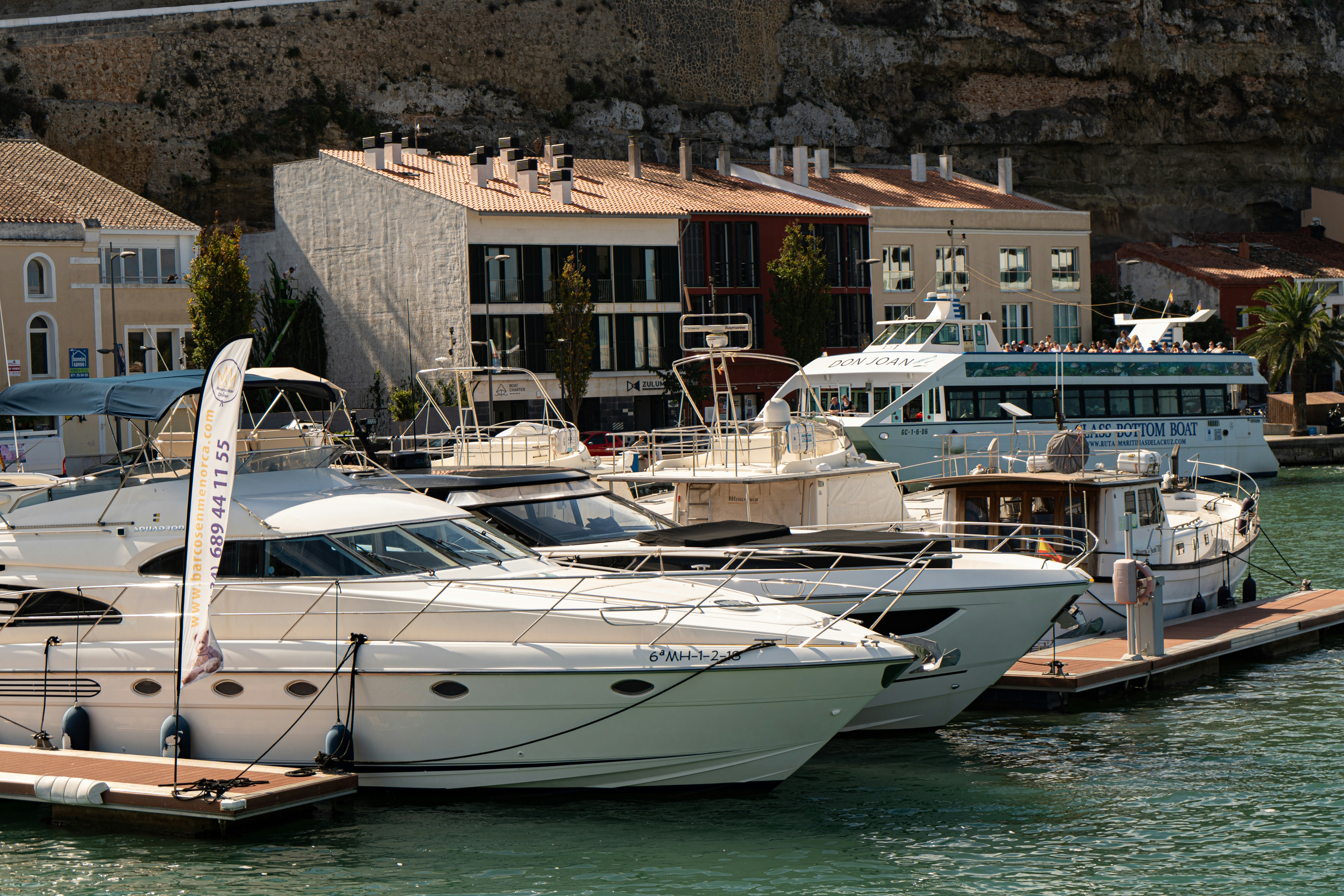Harbor Parade: White-Hulled Yachts Rest Along a Sunlit Marina