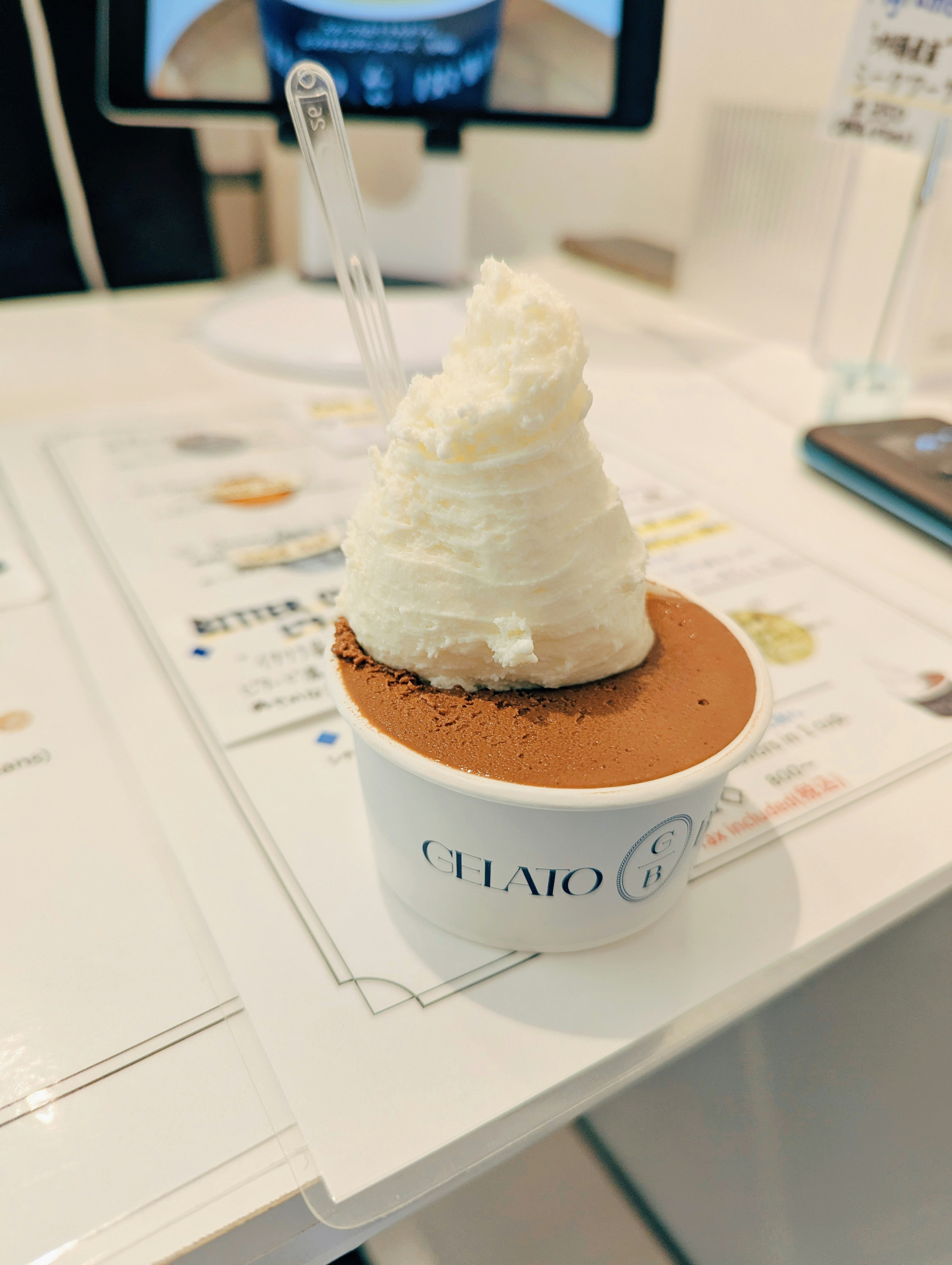 Cream Peak Rising from Cocoa-Dusted Gelato Cup in a Minimal Café
