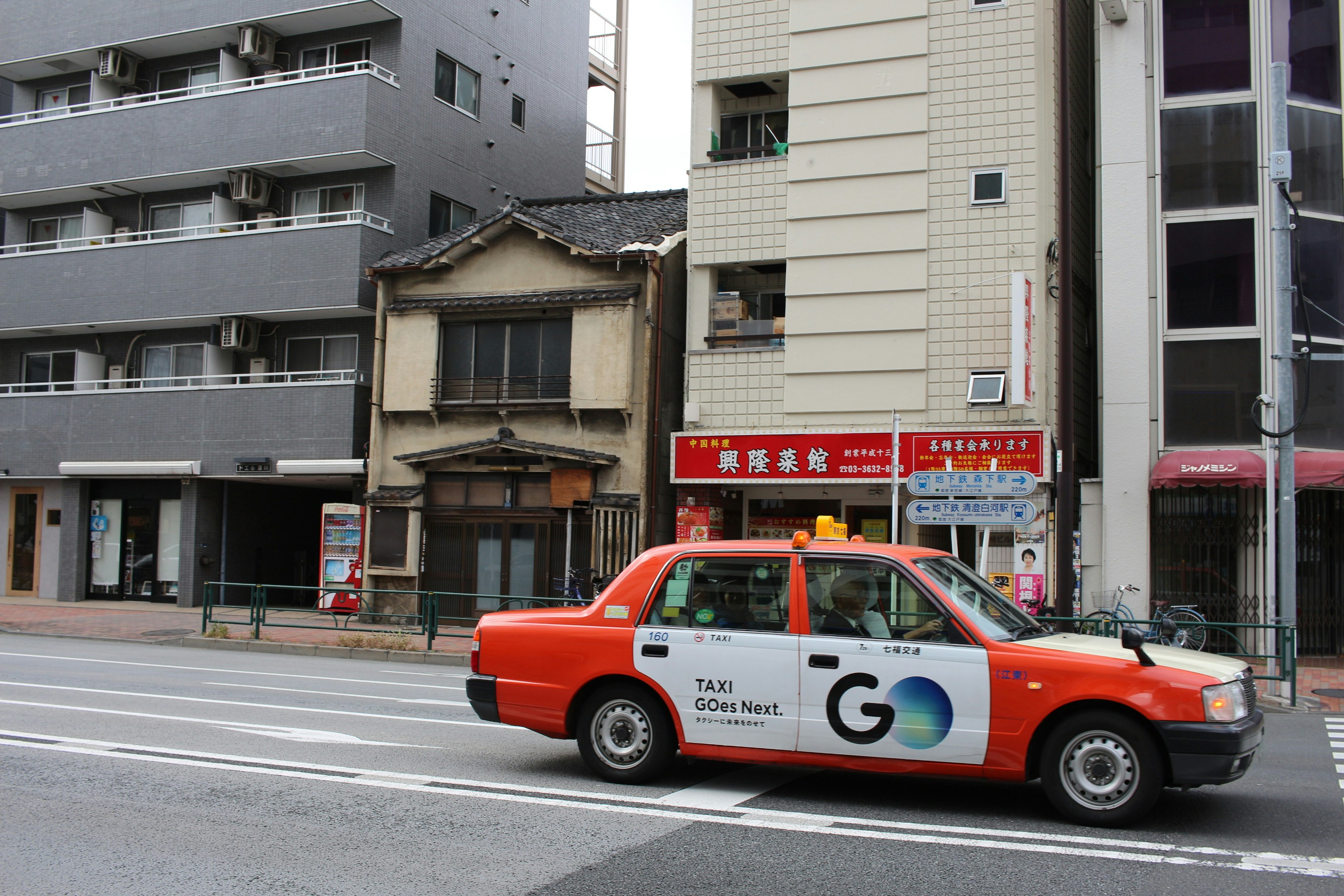 Orange Taxi in Motion Through a City of Contrasts