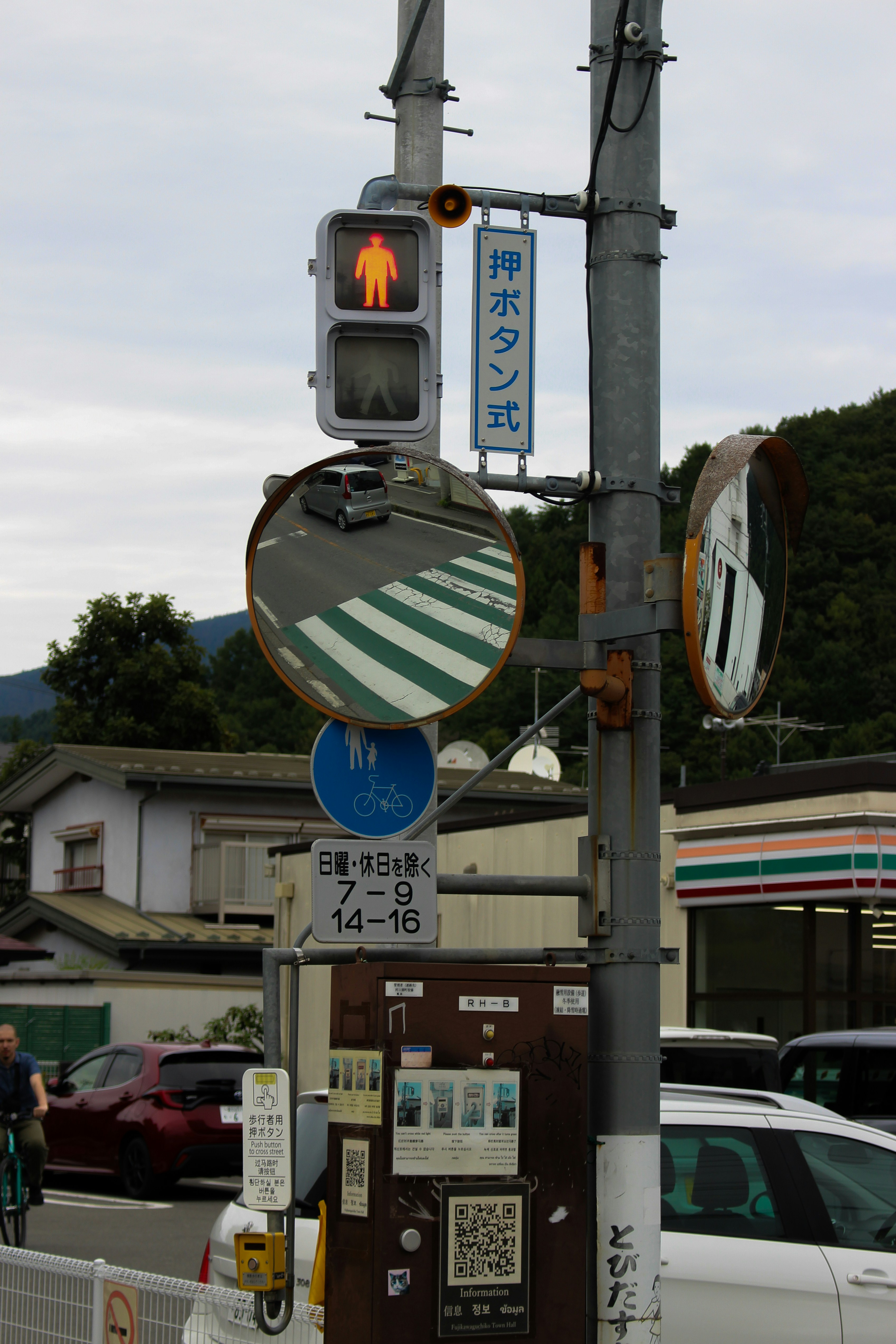 Orange Pedestrian Signal Framed by Circular Mirrors on a Japanese Street Corner