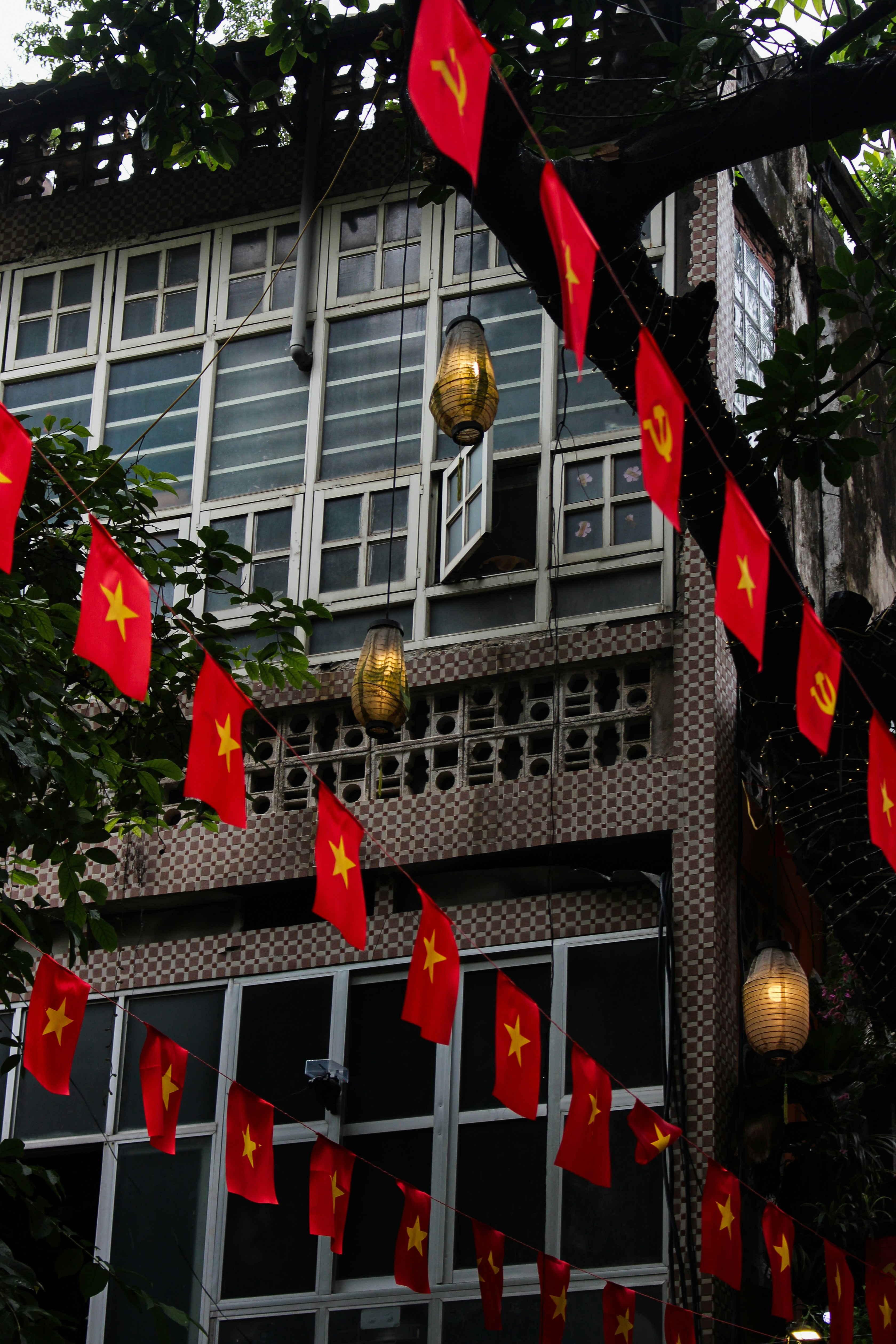 Lanterns Between Flags Over a Tile-Faced Courtyard