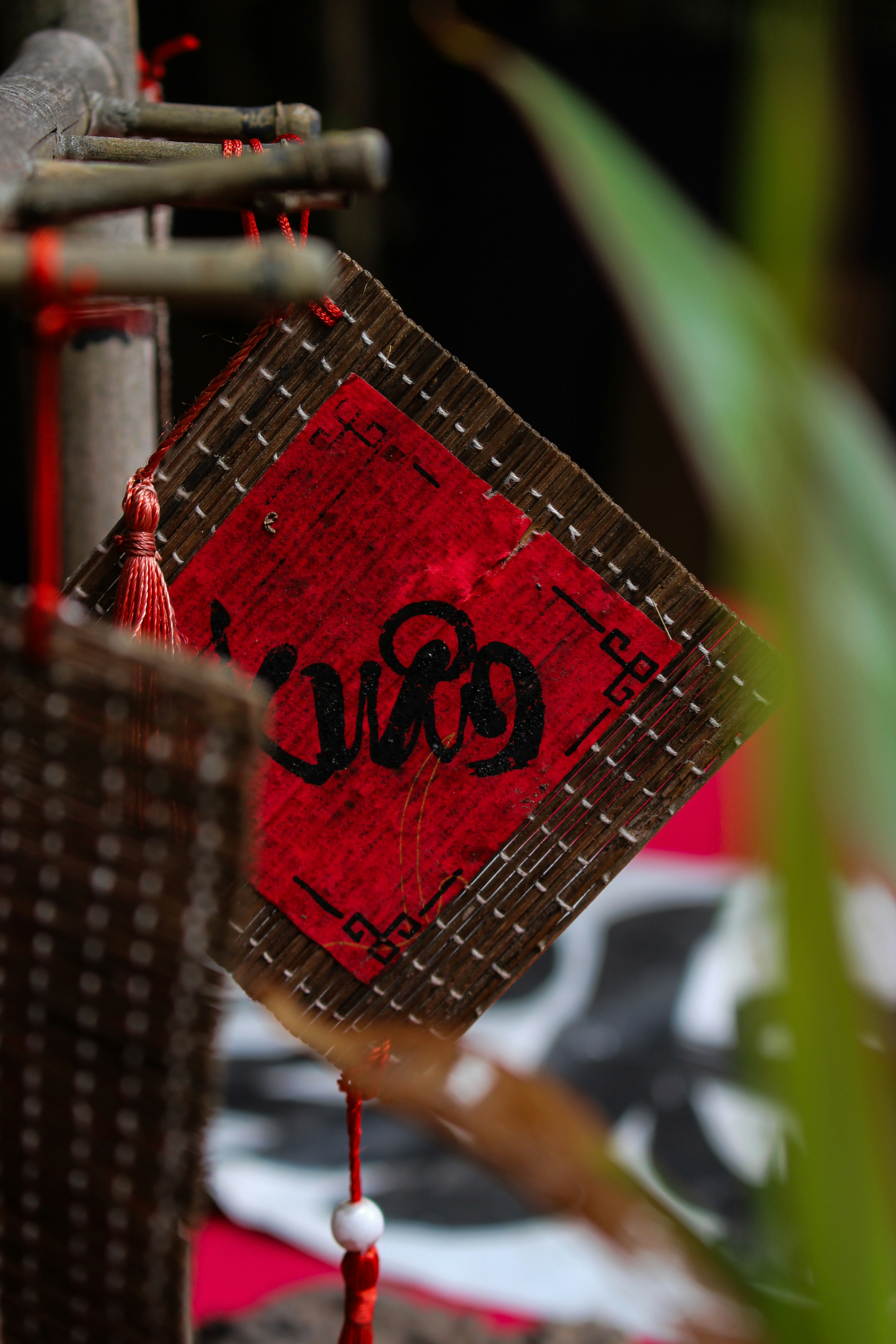 Red Blessing Tag Entwined in Rustic Bamboo Weave