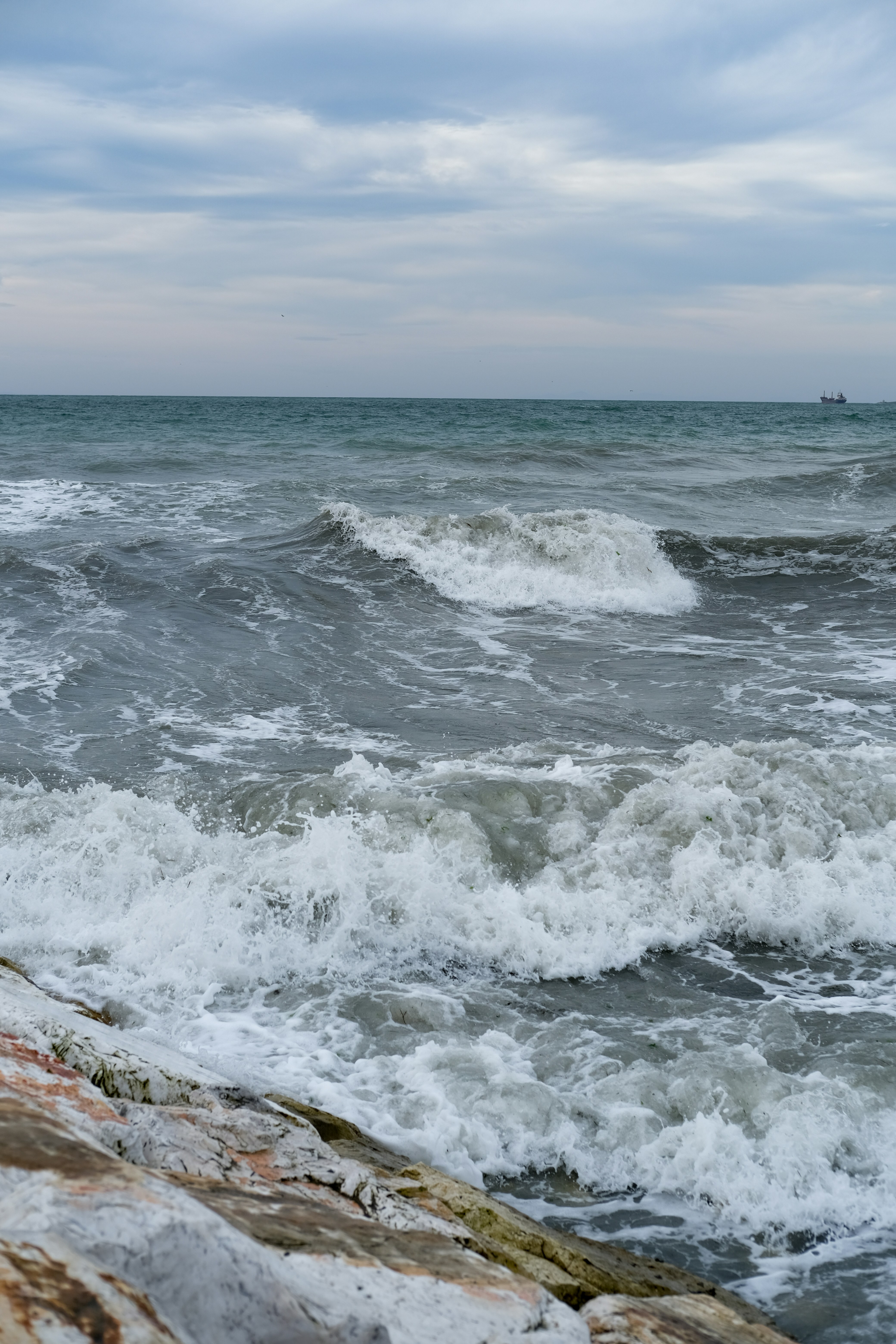 Foam-Tipped Breakwater: Waves Clash Over a Ragged Sea Wall