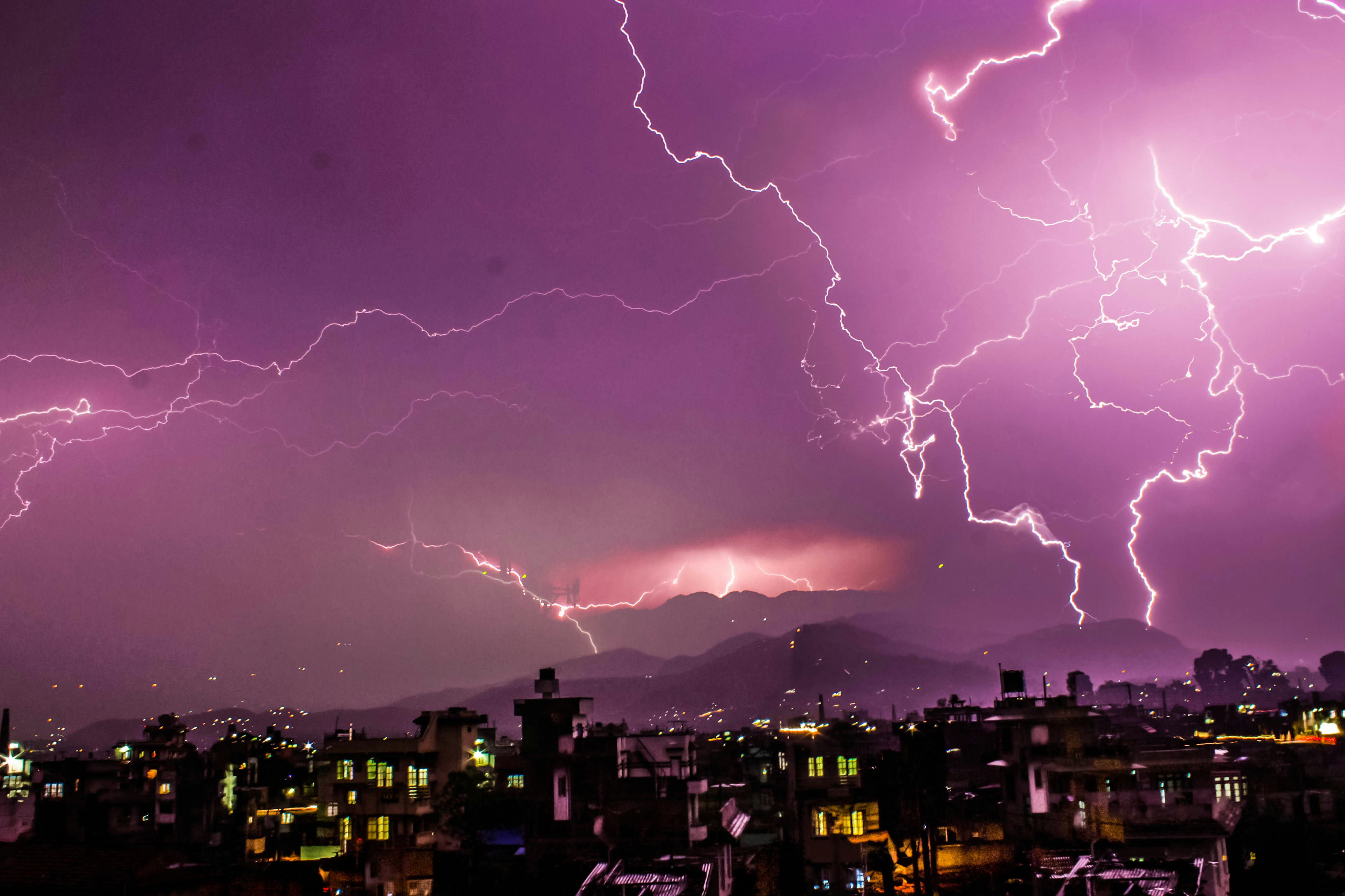 Violet Thunder Over a Night City and Mountain Ridge
