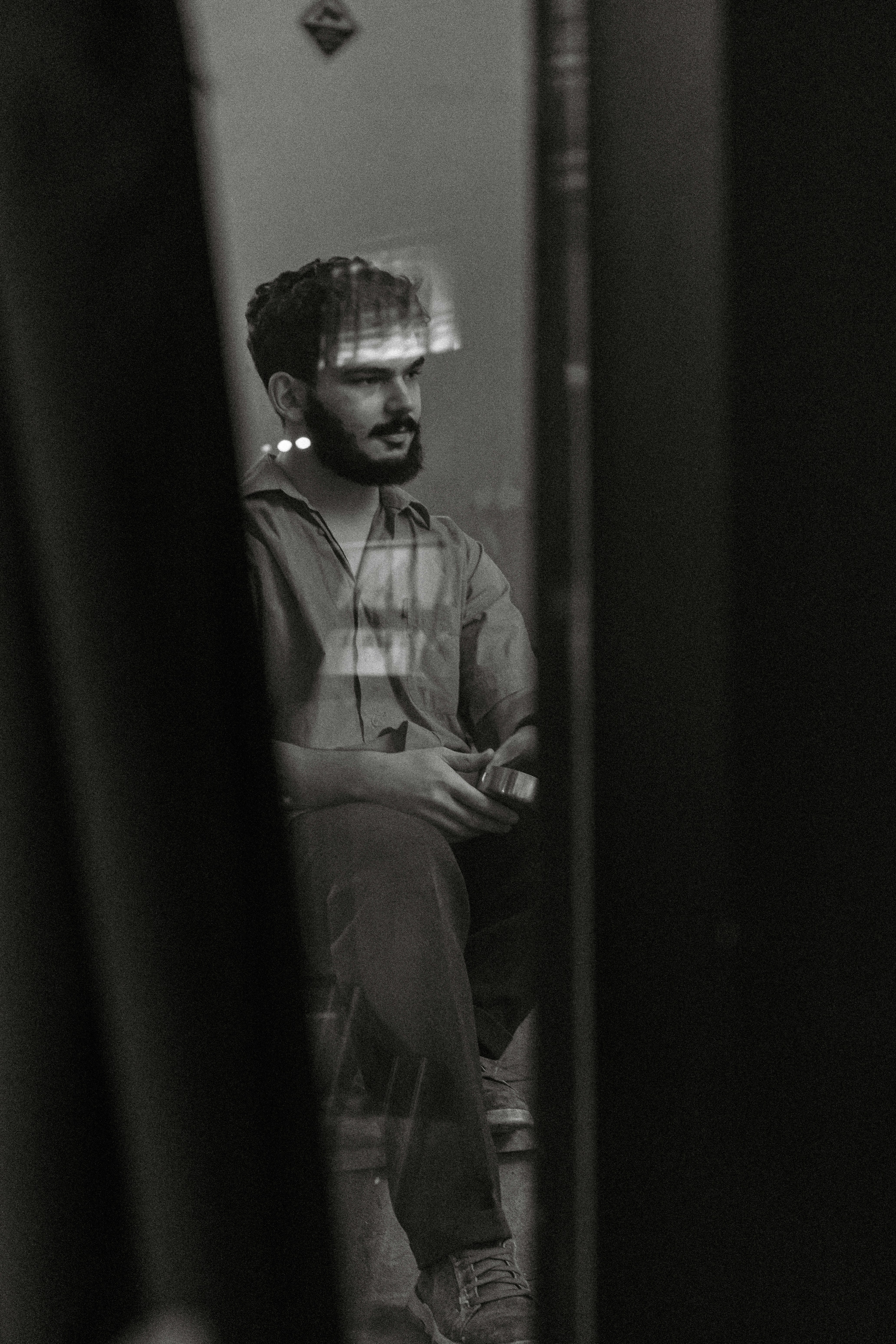Glass Reflections: A Contemplative Portrait in Mono