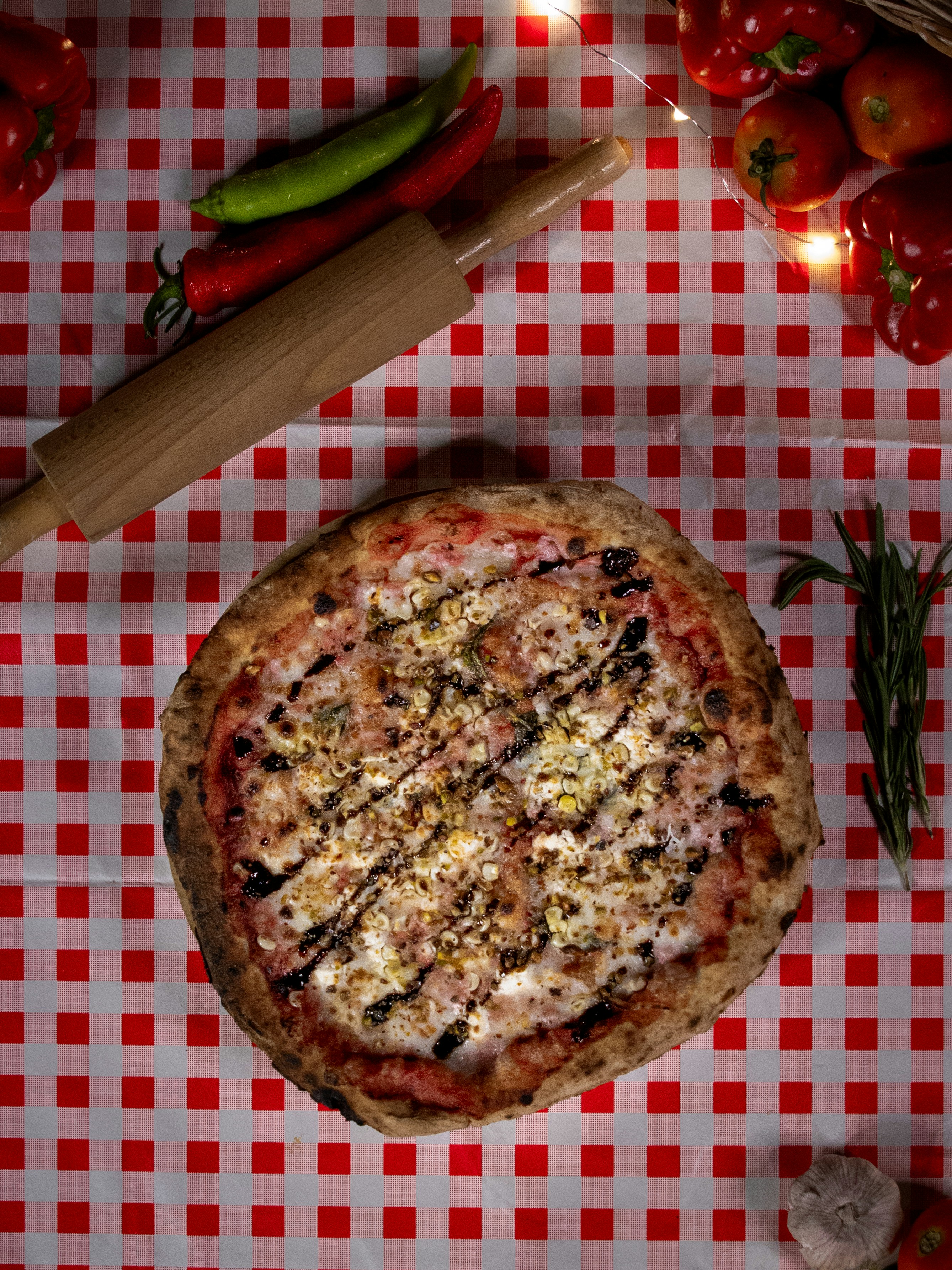 Rustic Pizza on a Checkered Table: Charred Cheese and Fresh Herbs