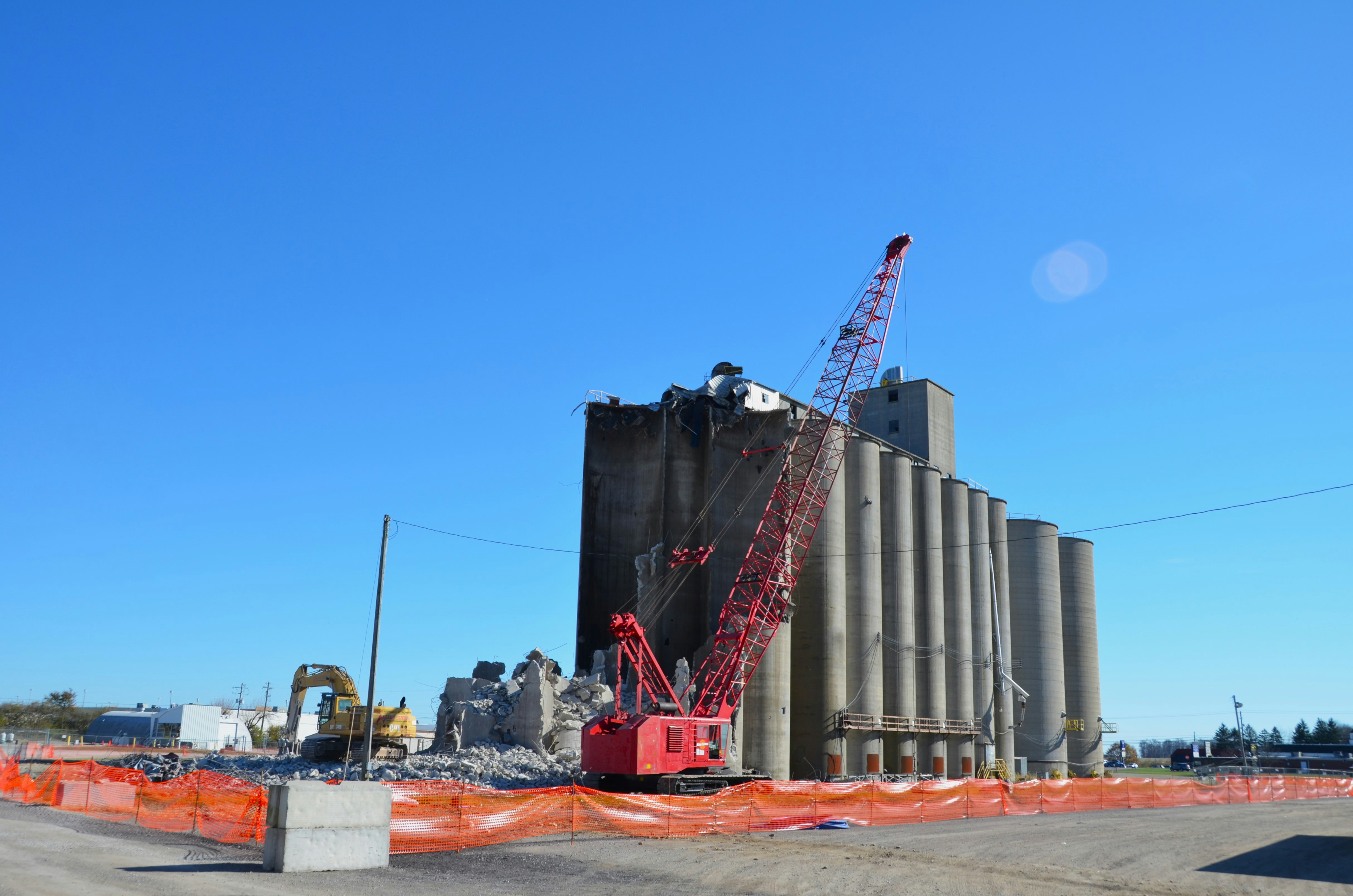 Crane Arc Over a Row of Silos in a Bright Construction Yard