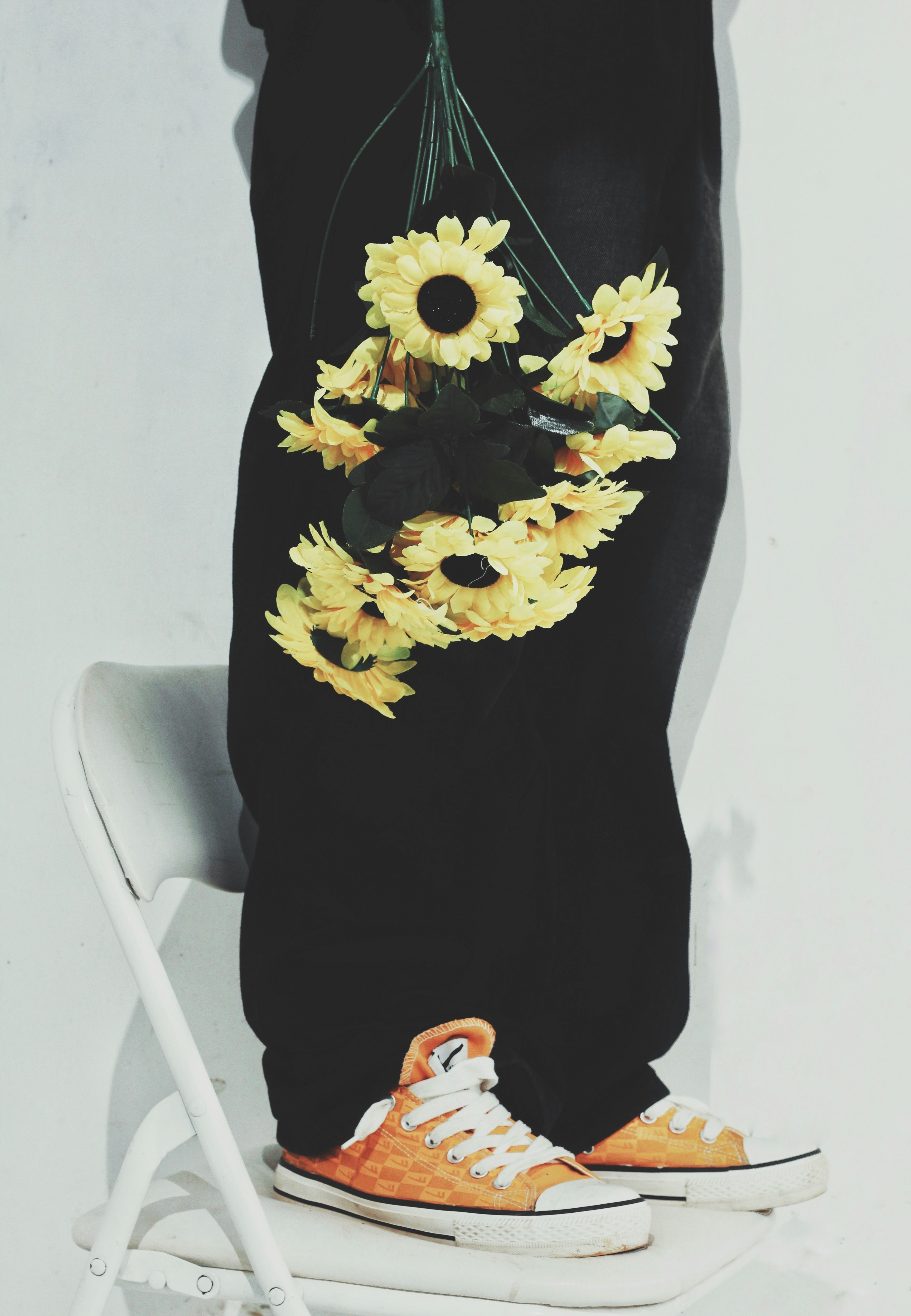 Sunflowers on a White Chair: A Hanging Bouquet Above Neon-Orange Sneakers