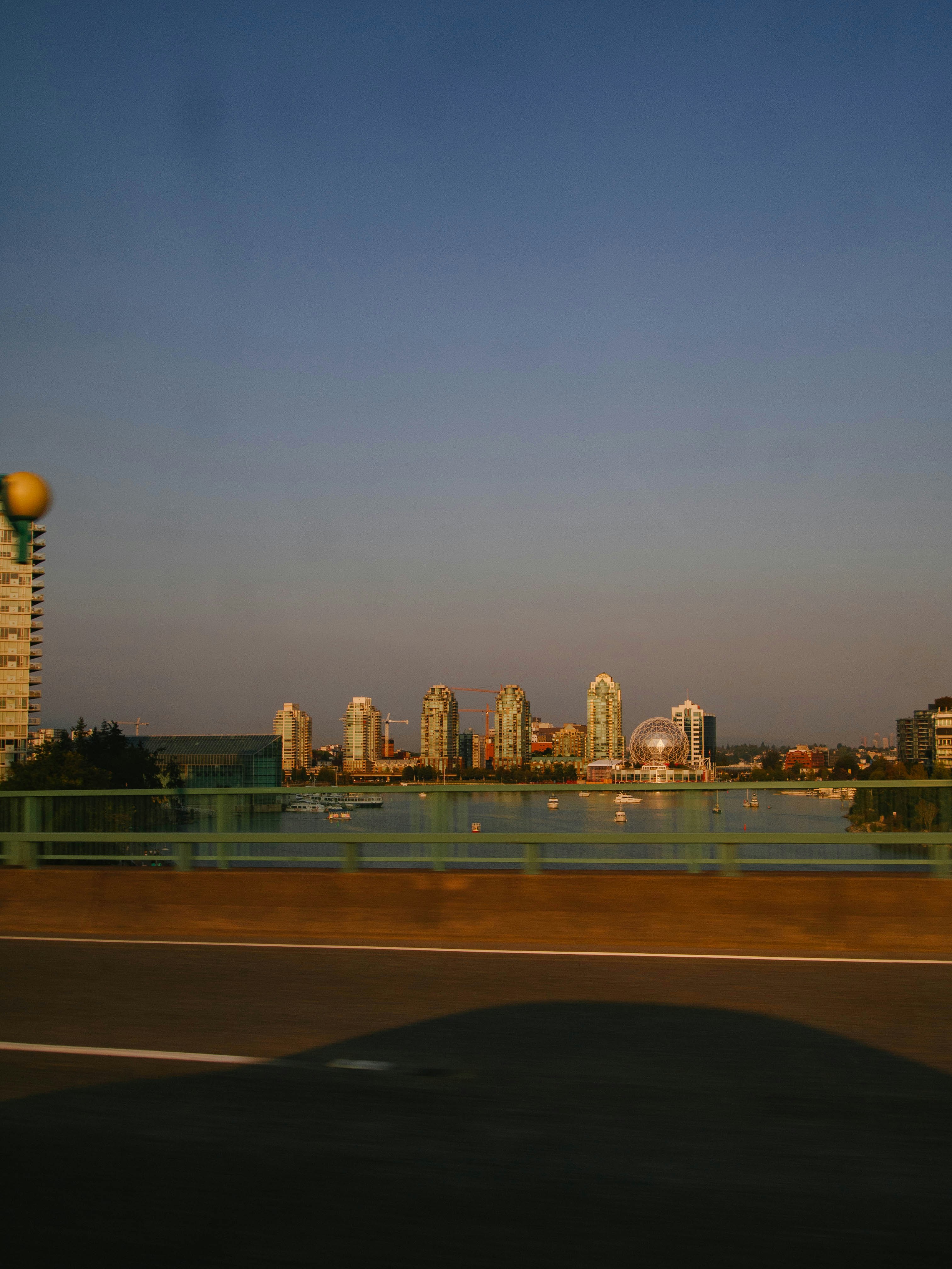 Golden Hour Over the River: A Modern Skyline Framed by a Moving Bridge