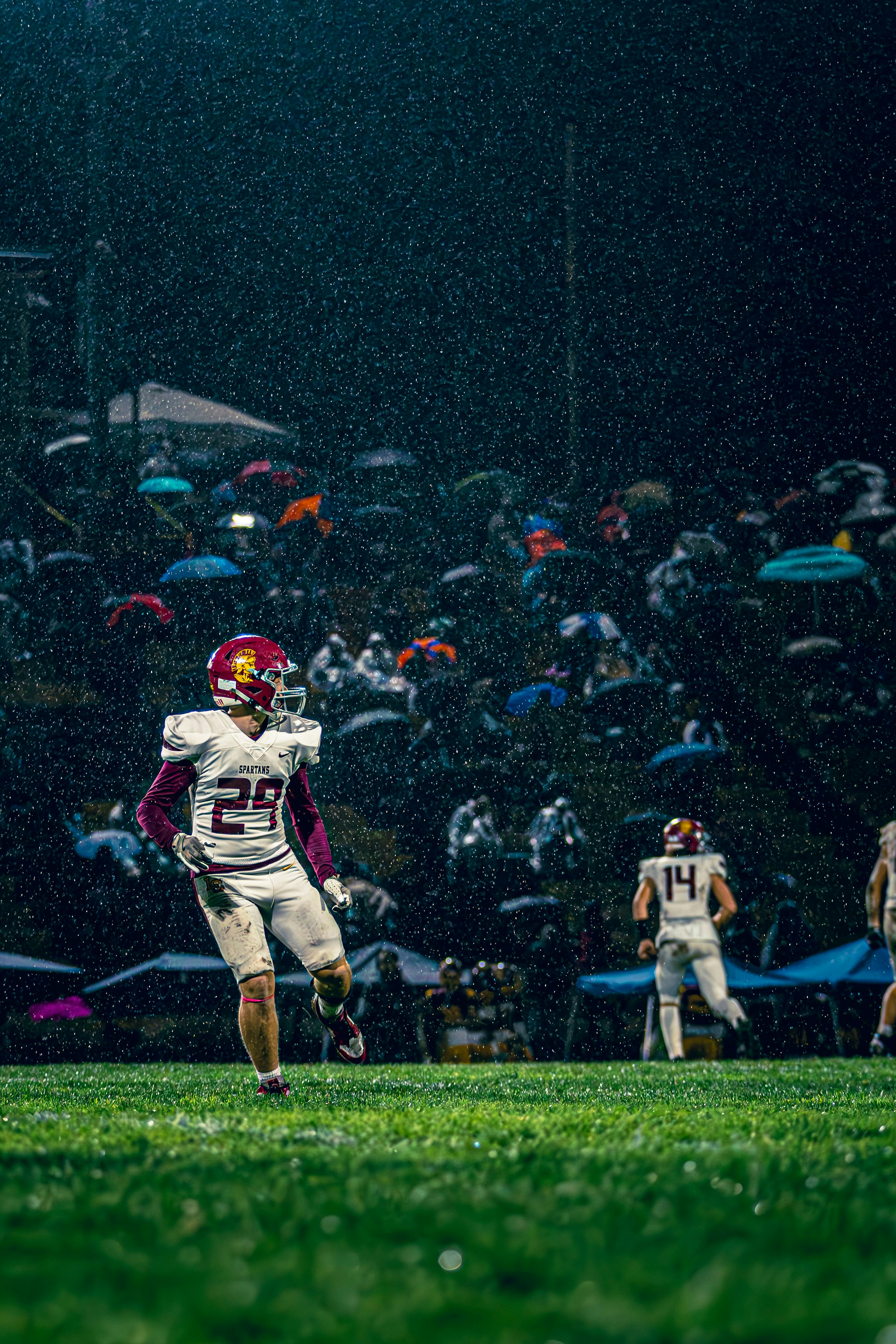 Rain-Swept Gridiron: The Sprint of #25 Through a Stadium Storm
