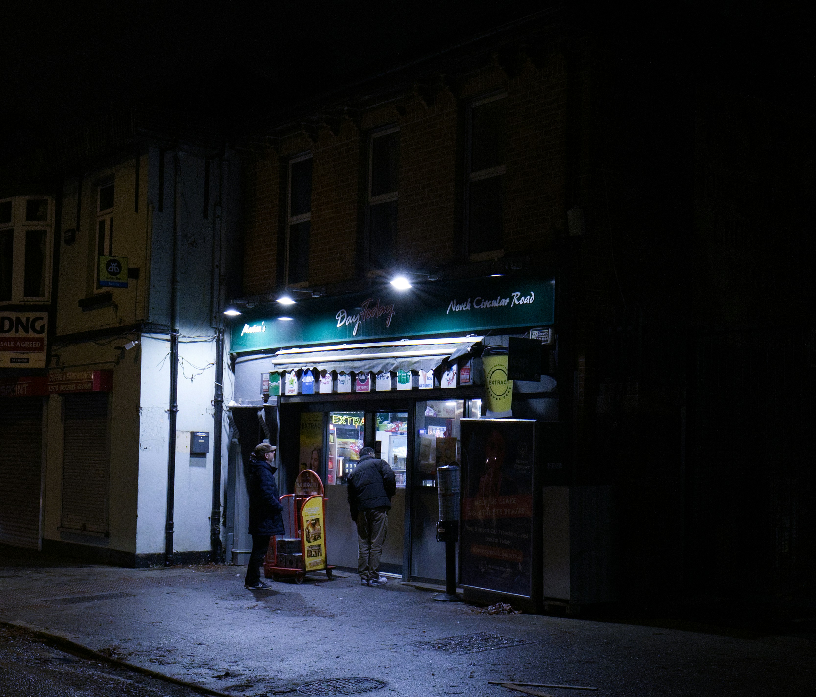 Blue Neon Nightfront: Two Pedestrians at a Quiet Corner Store
