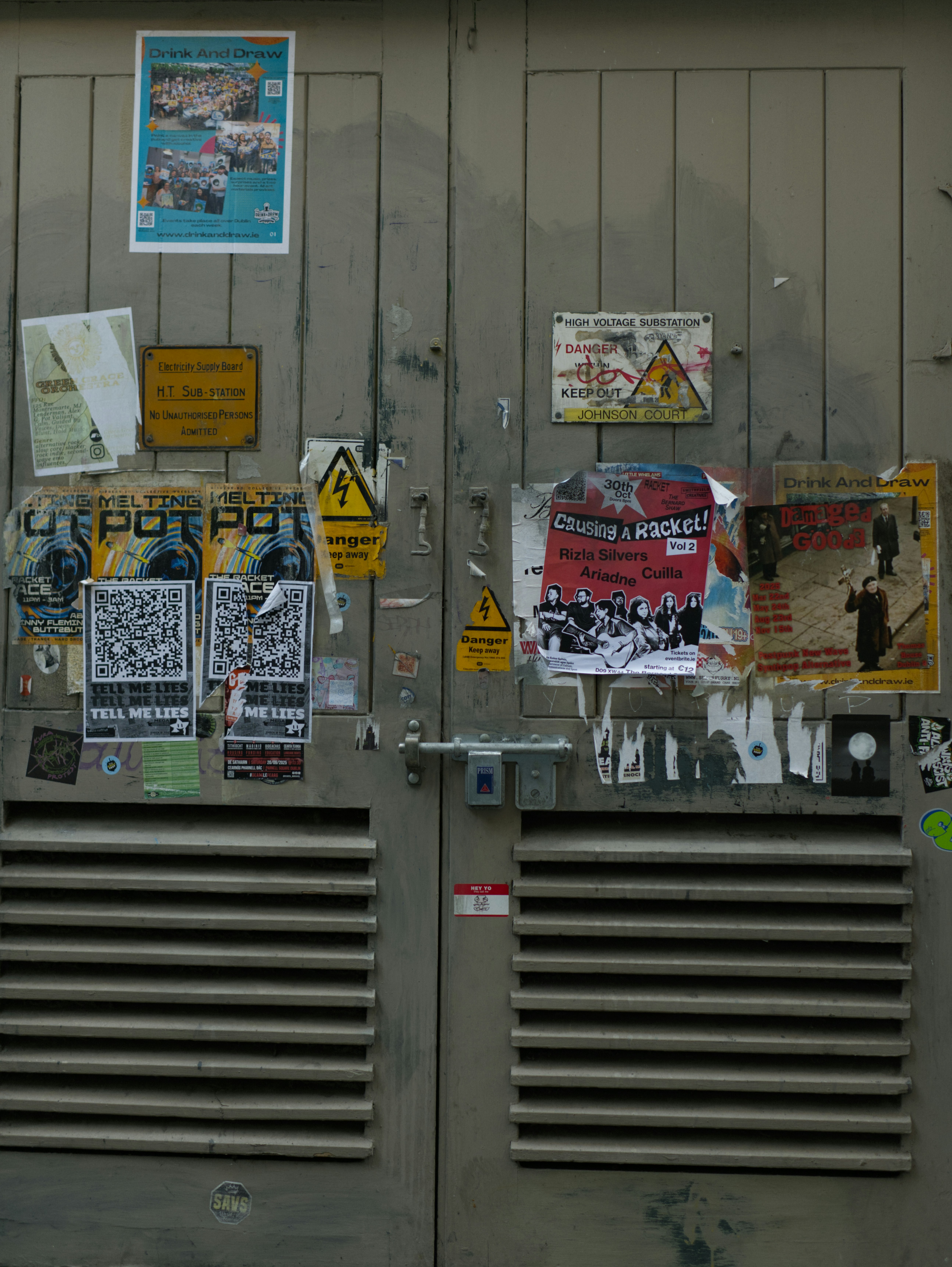 Layered Signals on Steel: A Door Dressed in Posters and Warnings